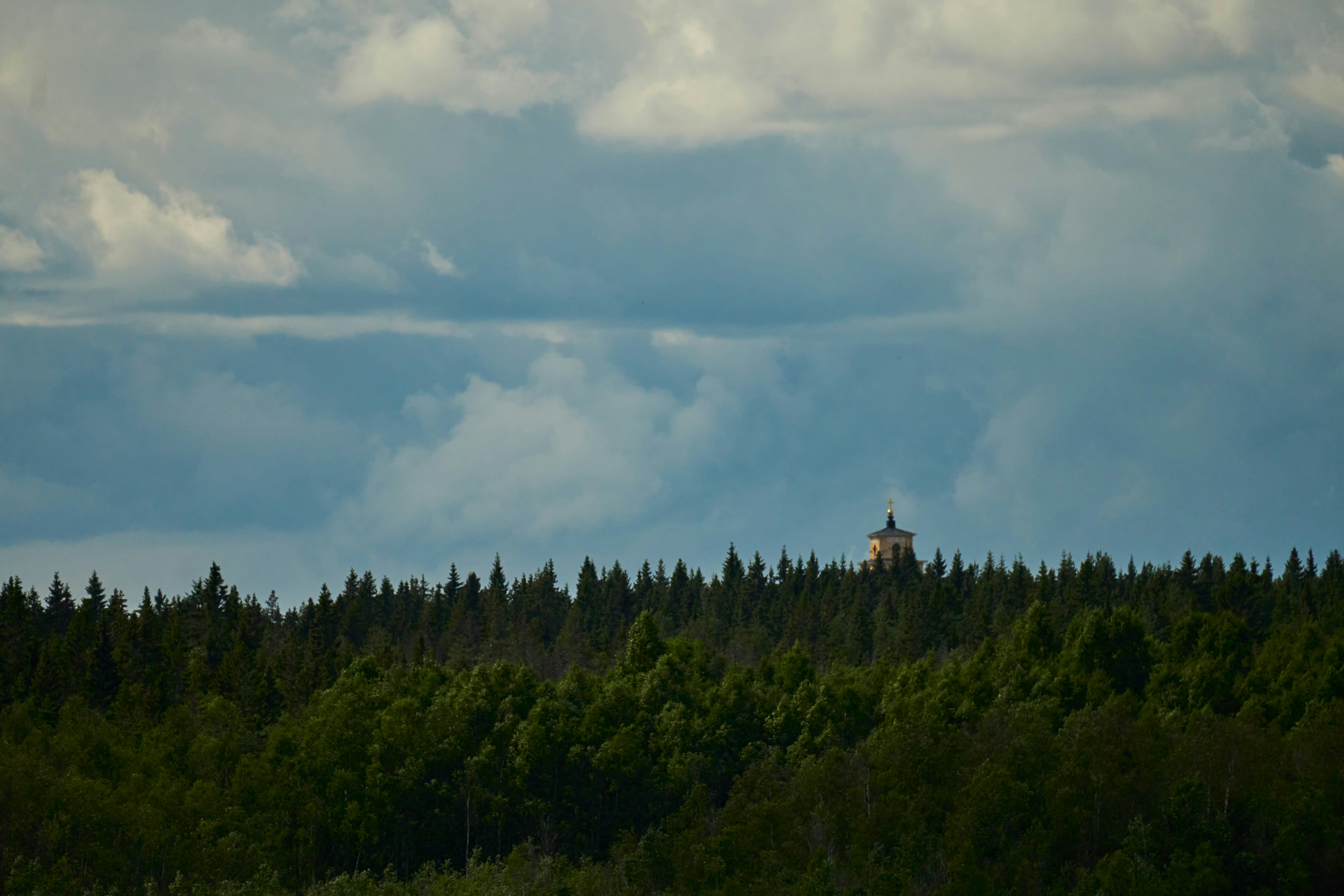 Gammelstad's church tower can be seen behind some trees from a lookout spot at Gammelstadsviken.