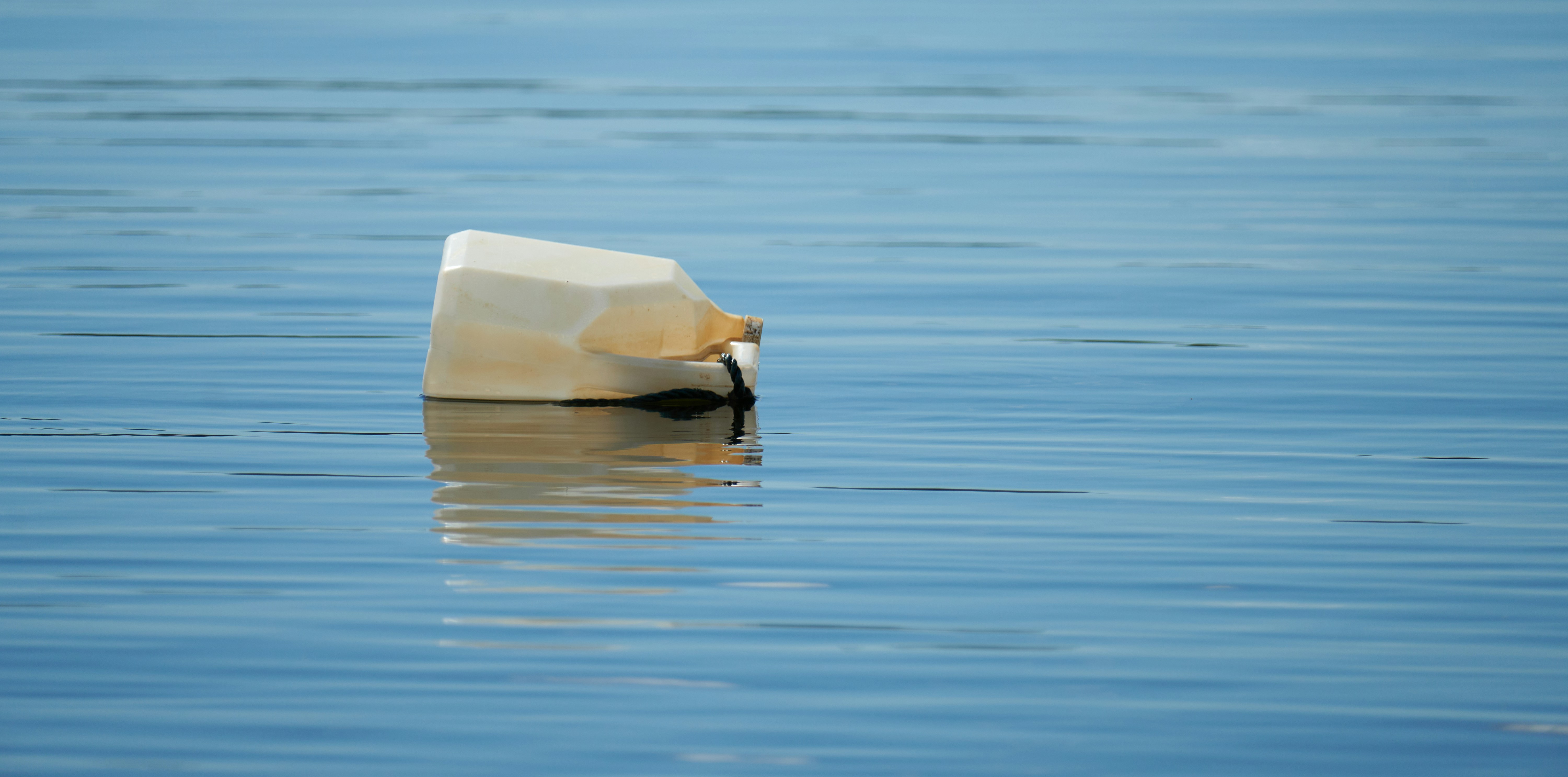 Lone White Block Drifts Across a Glassy Blue Lake