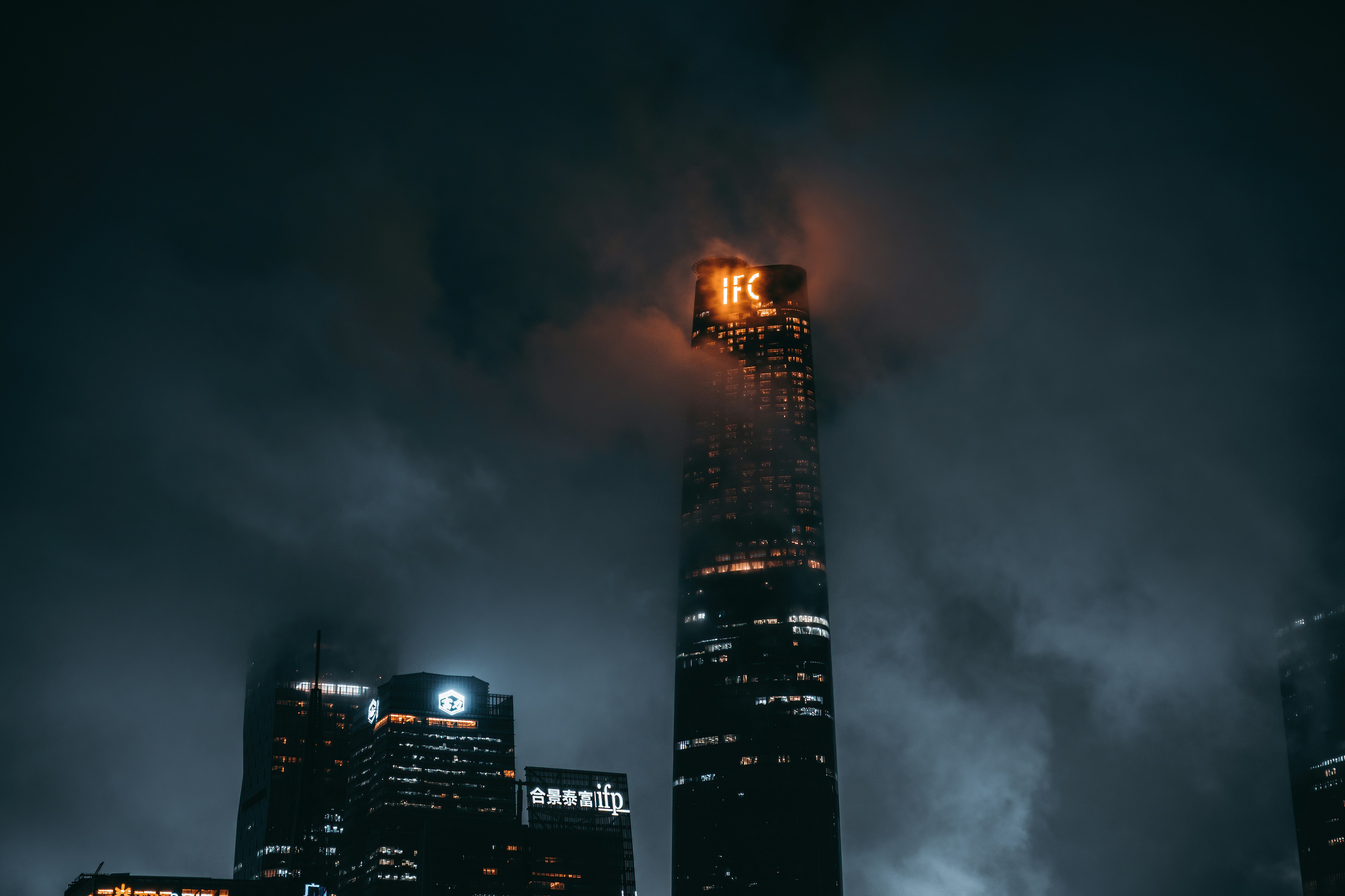 Fire-Crowned IFC Tower Piercing a Fog-Kissed Night Skyline