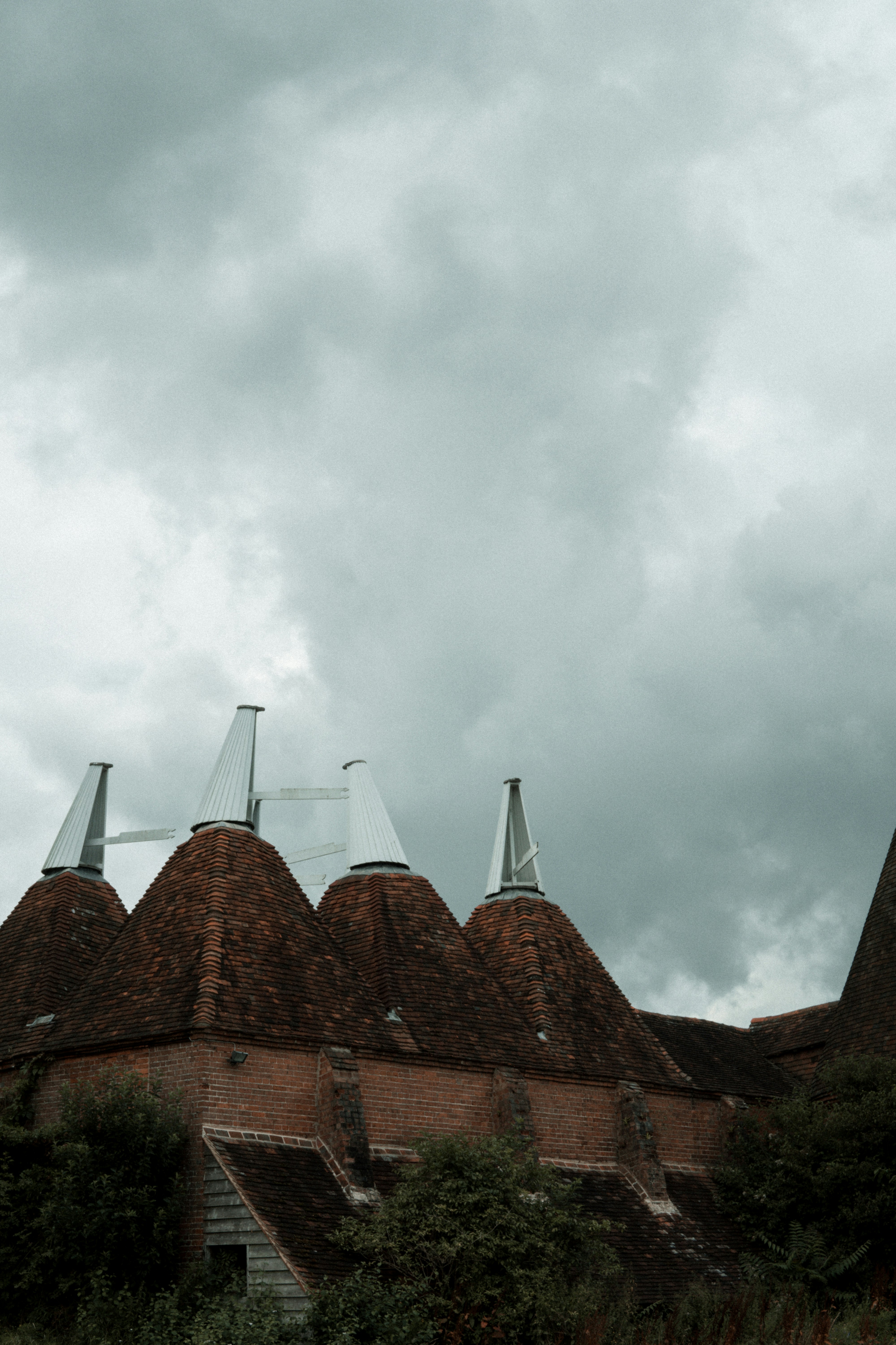 Brick Roofs Crowned with White Spires Beneath a Moody Sky