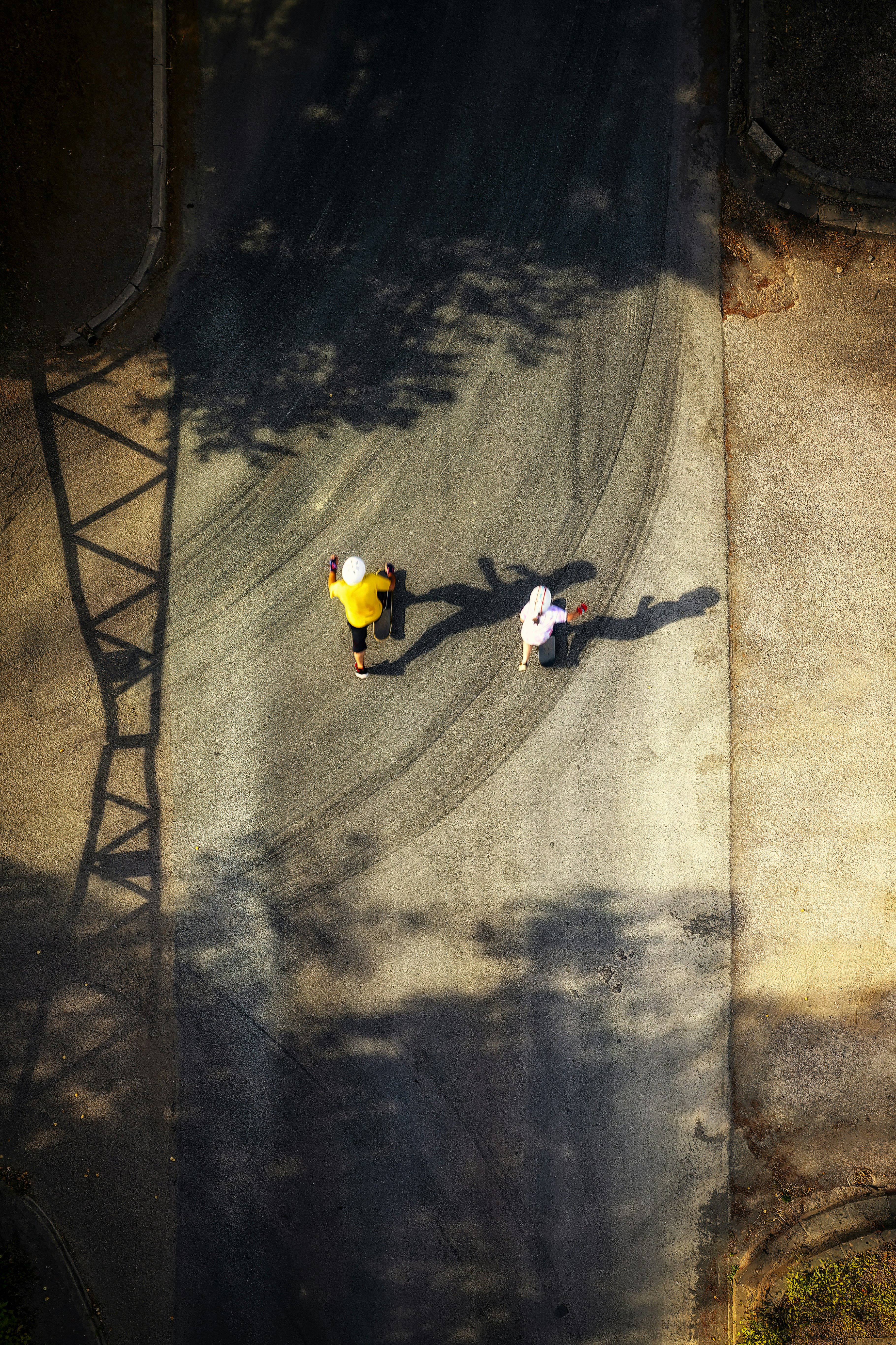 Crossing under a lattice shadow: two pedestrians on a sunlit road