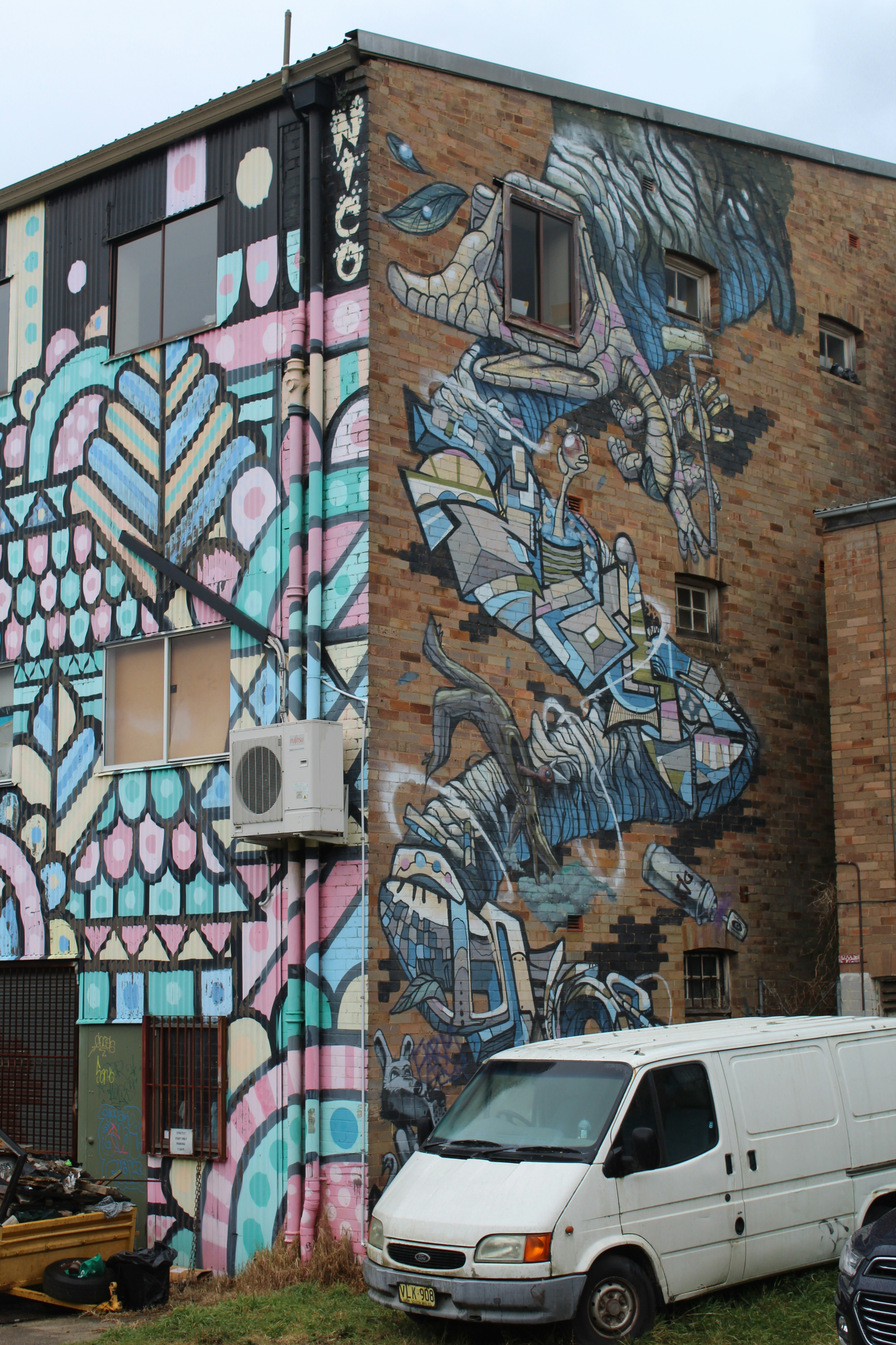 Une camionnette garée devant un immeuble avec des graffitis dessus ...