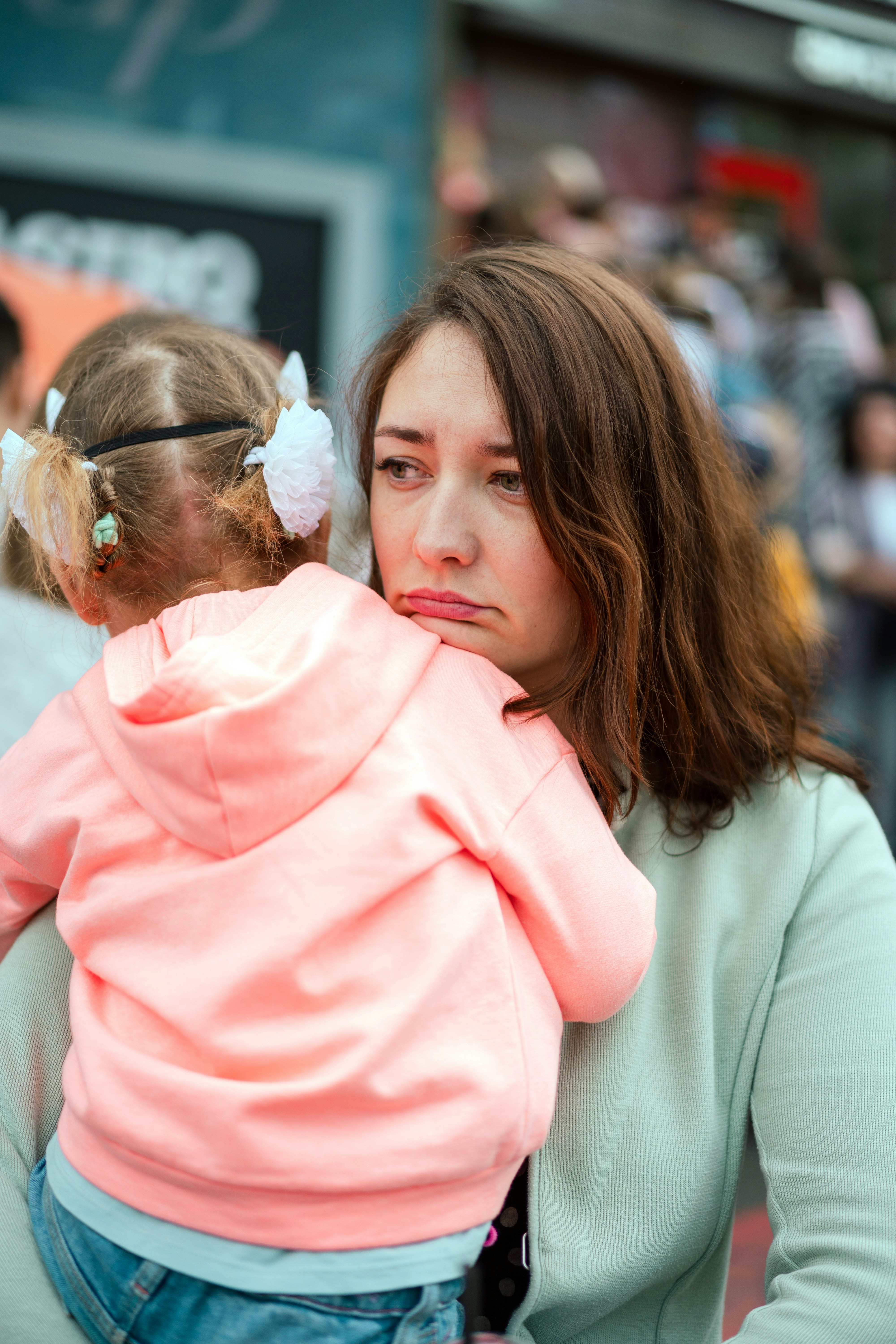 A Quiet Gaze Amid the Crowd: Mother and Daughter in a Bustling Street