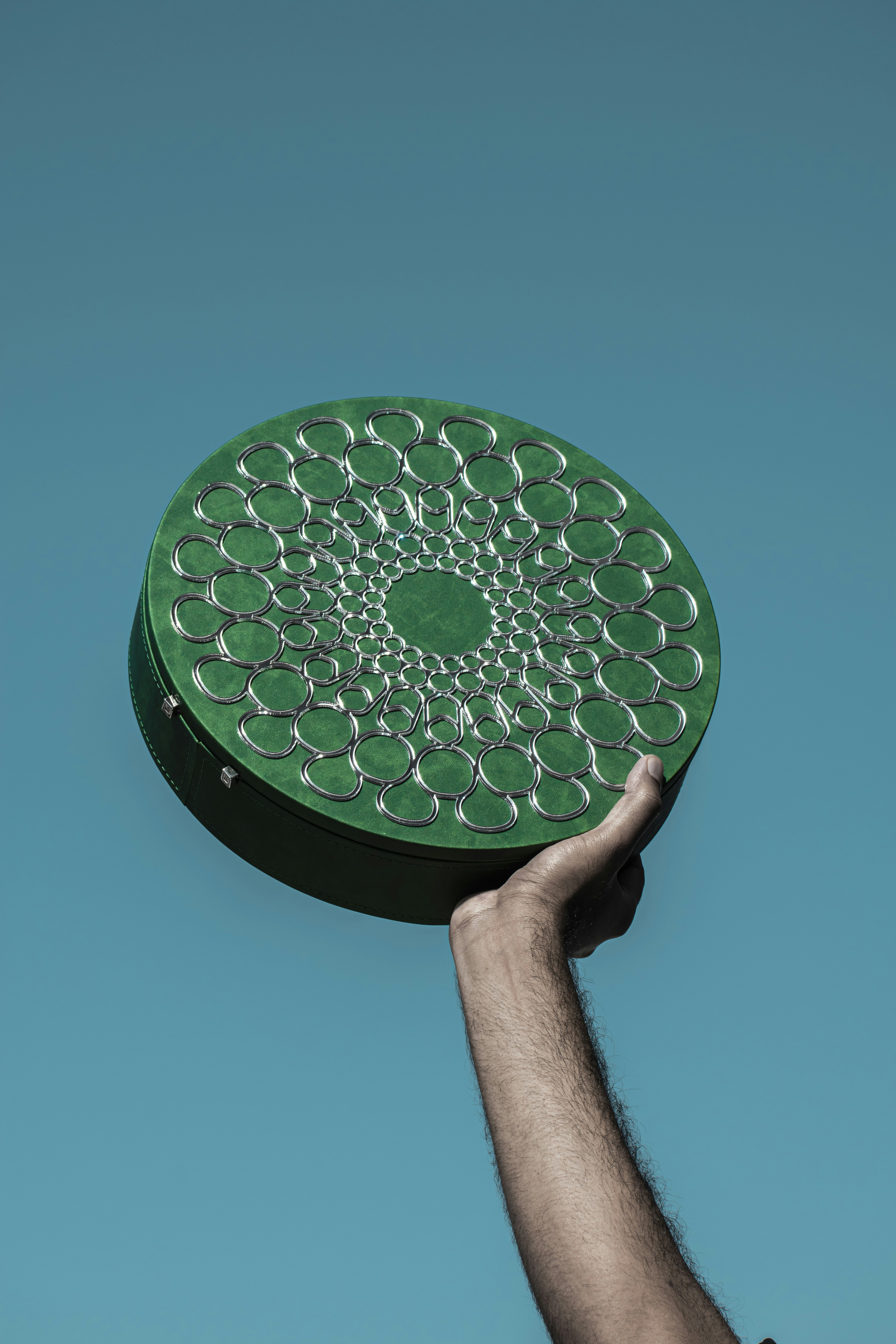 A hand holding a green circular object photo – Free Dubai - united arab ...