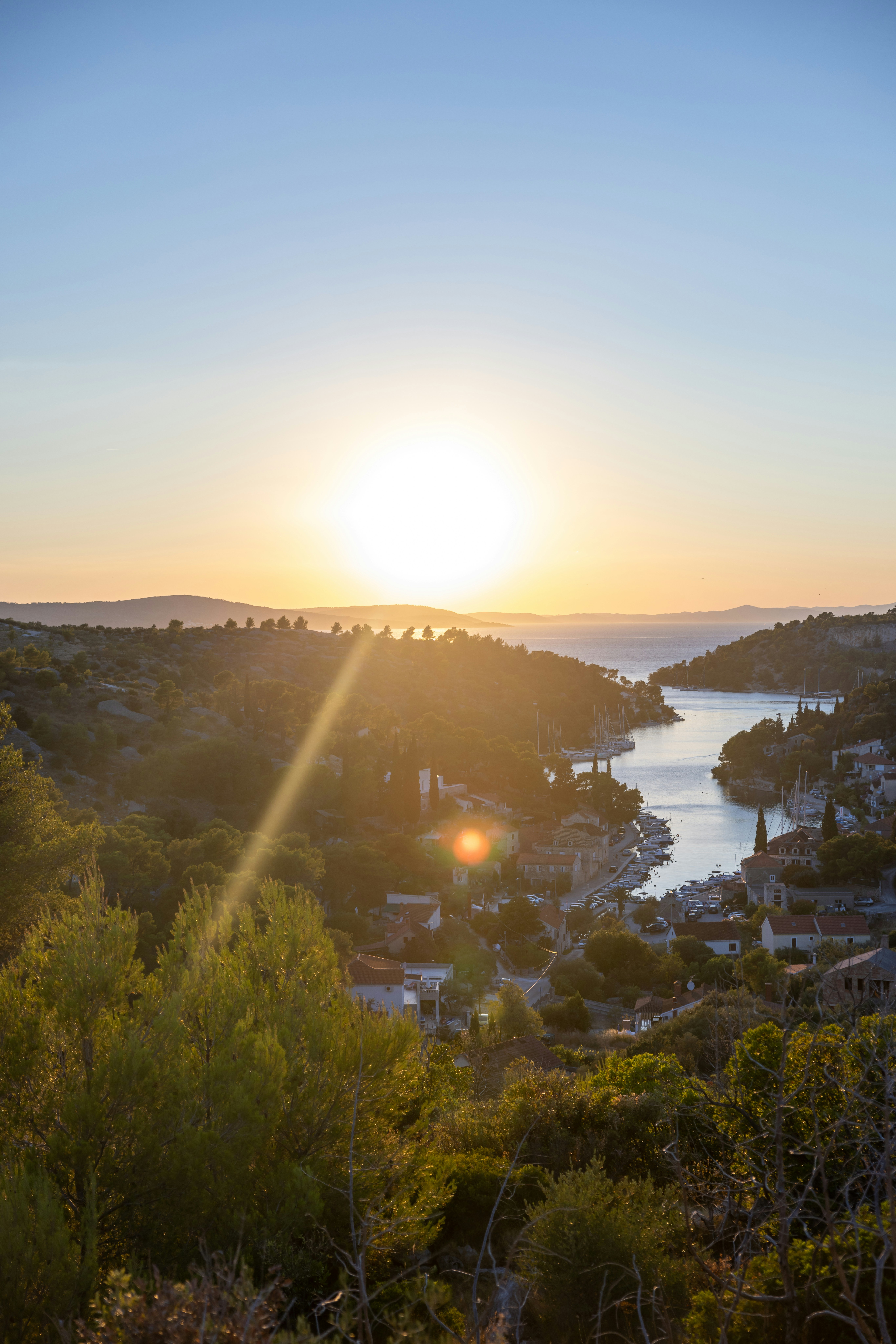 A landscape with trees and a body of water with a sunset photo – Free ...