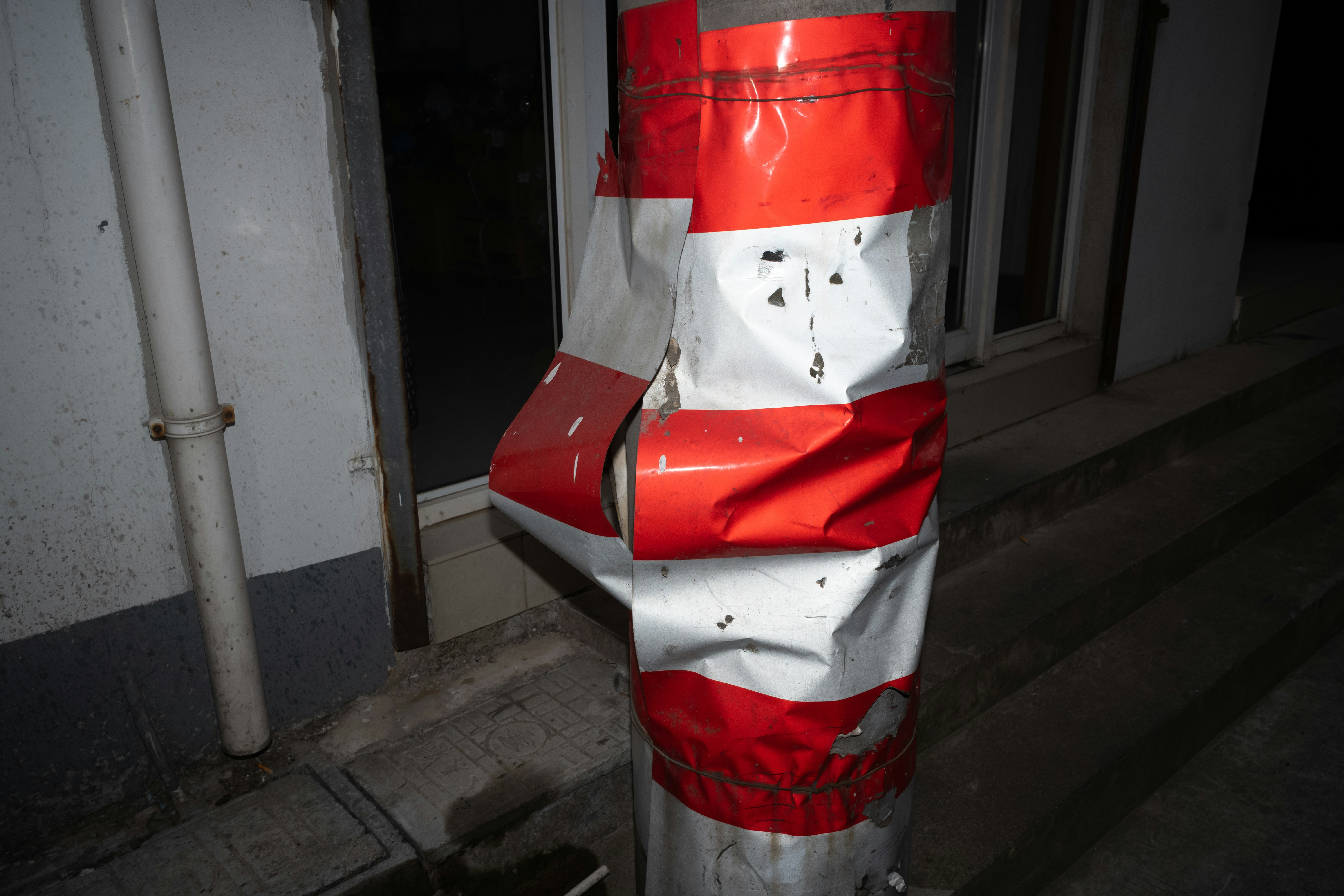 Caution Tape Sentinel at the Edge of a Dim City Street