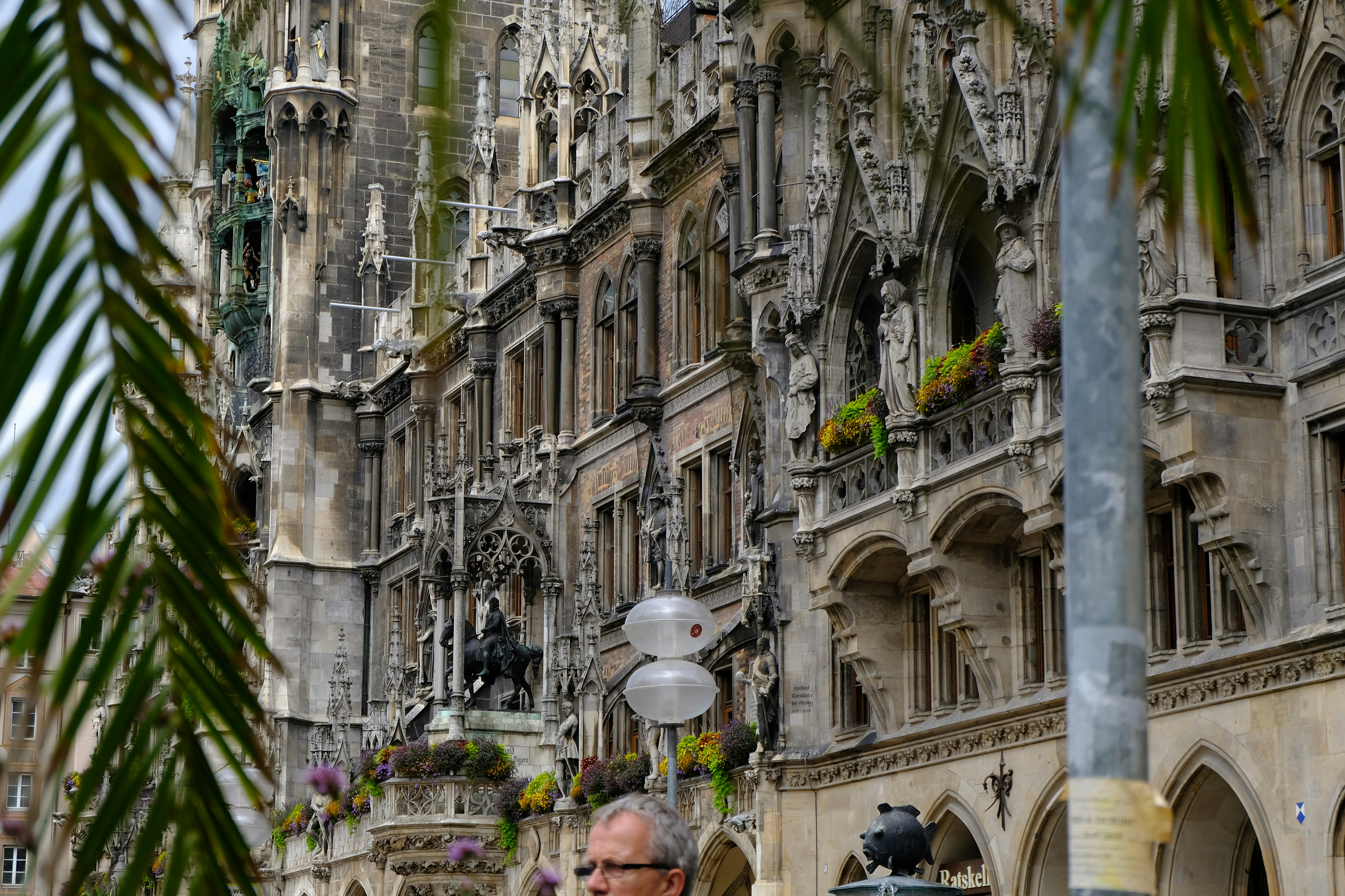 Gothic Facade Close-Up: Palm-Framed Sculptural Detail