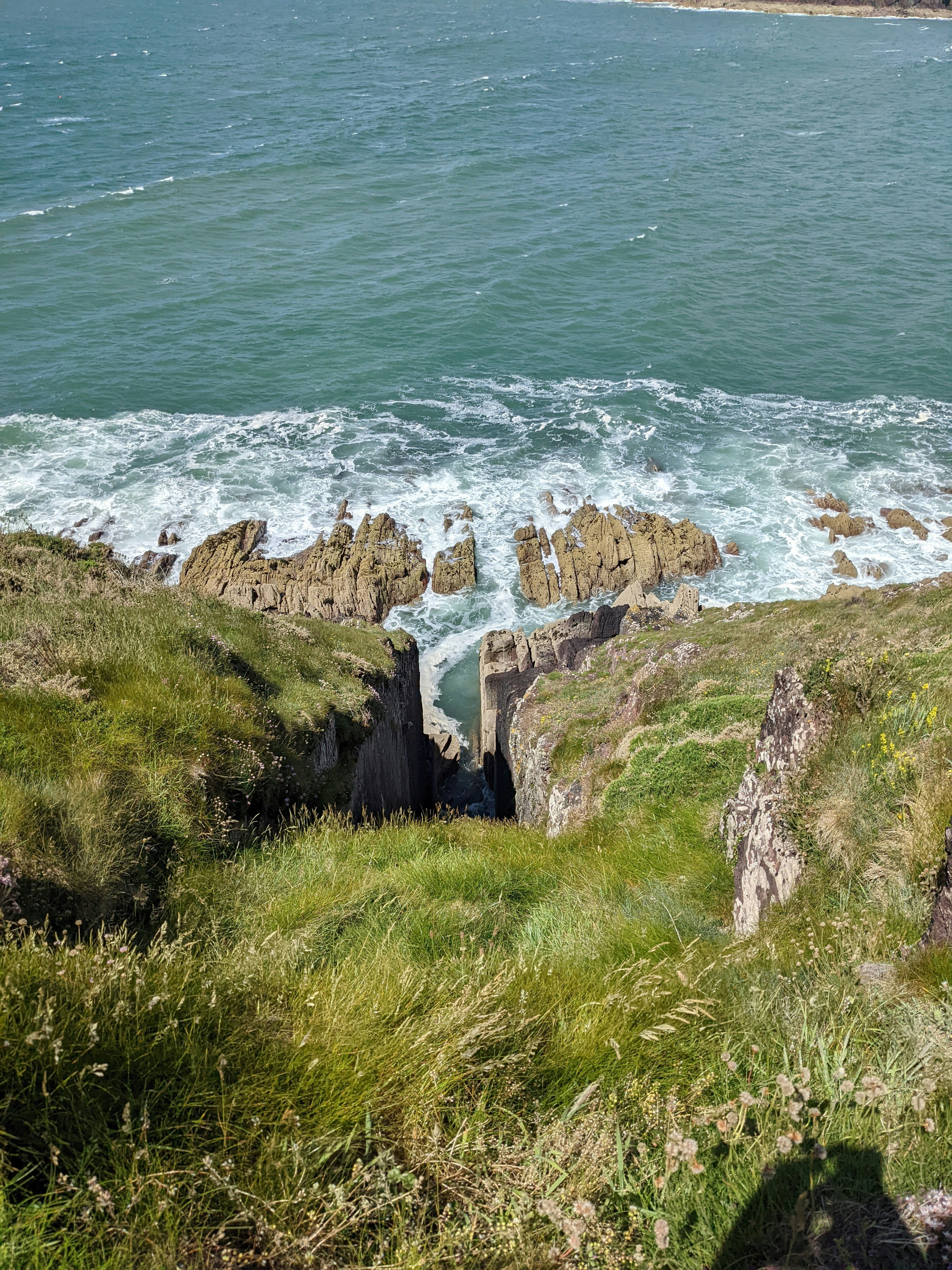 Foto Un acantilado rocoso con un cuerpo de agua en el fondo – Imagen ...