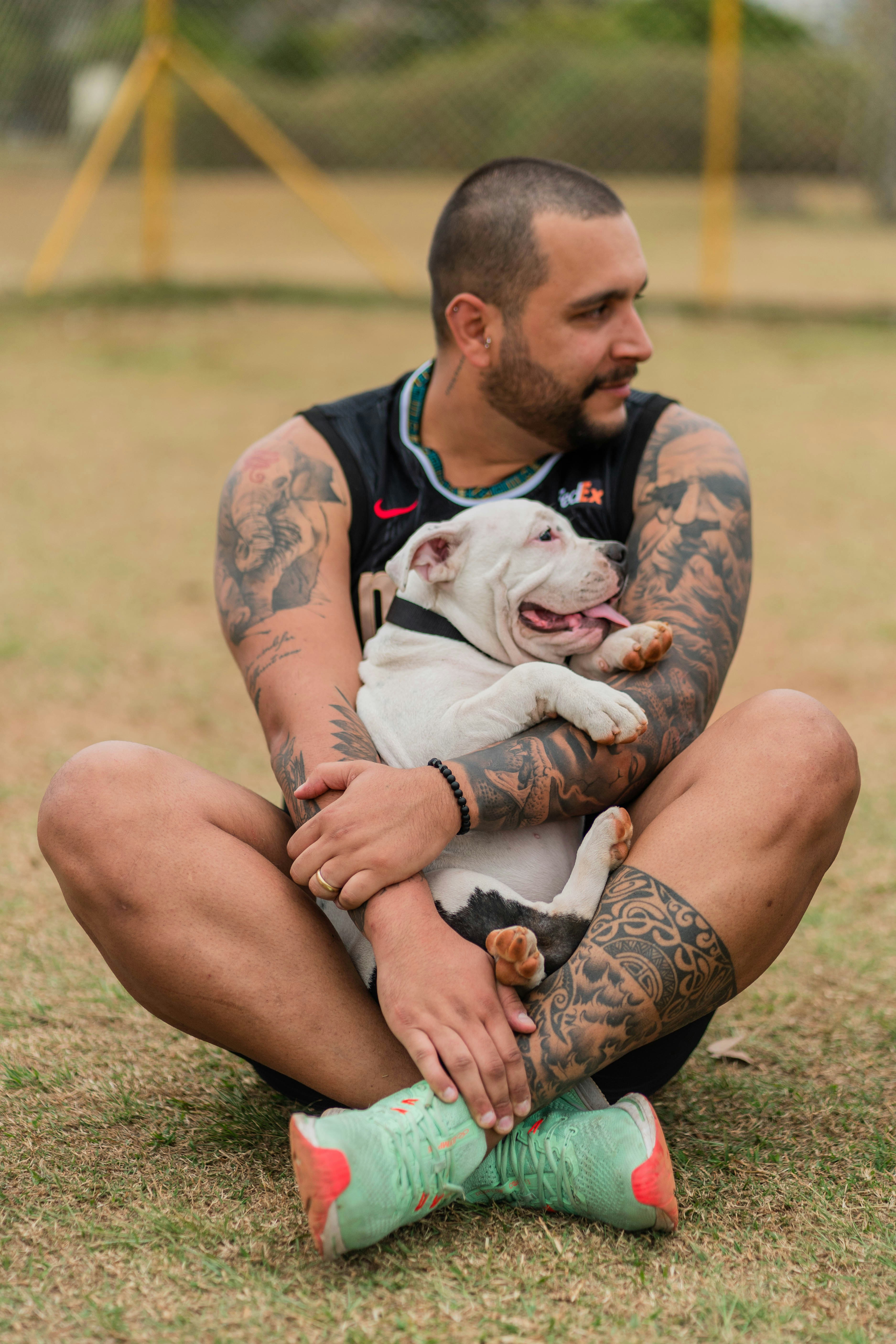 Tethered Trust: A Man and His Bullterrier in a Sunlit Park