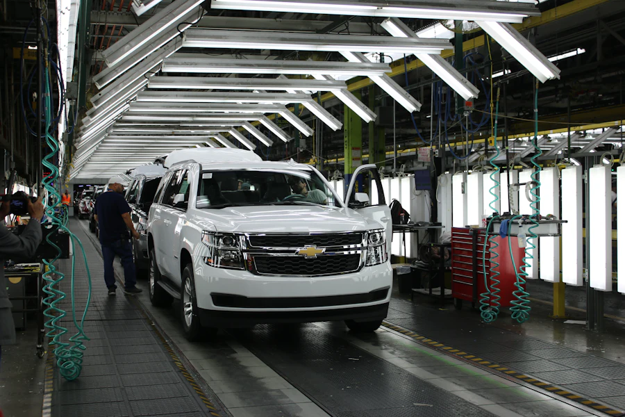 A Chevrolet SUV moves along a brightly lit assembly line, showcasing the intricate process of vehicle manufacturing in a modern factory environment.