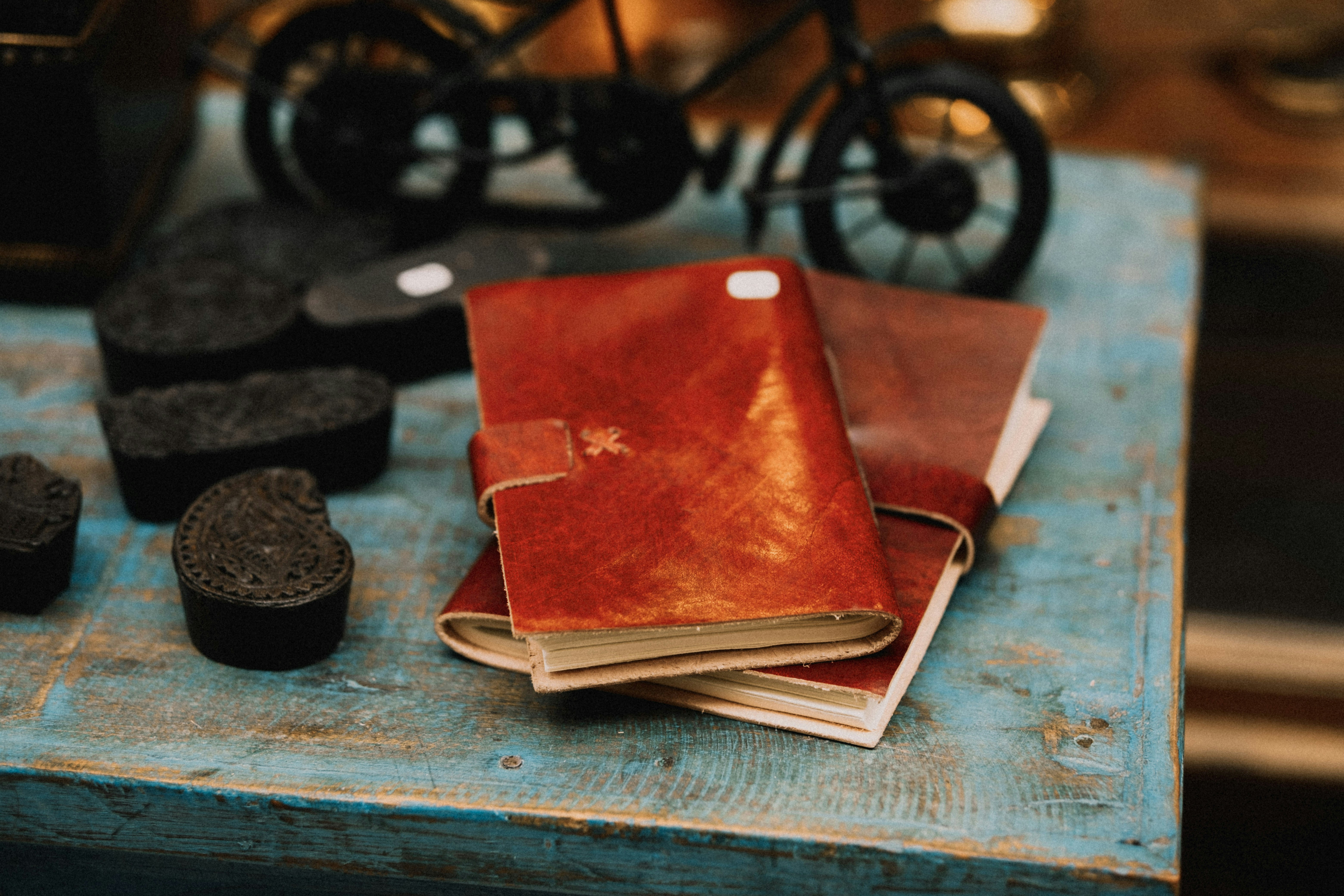 Red Leather Journals on a Weathered Blue Table