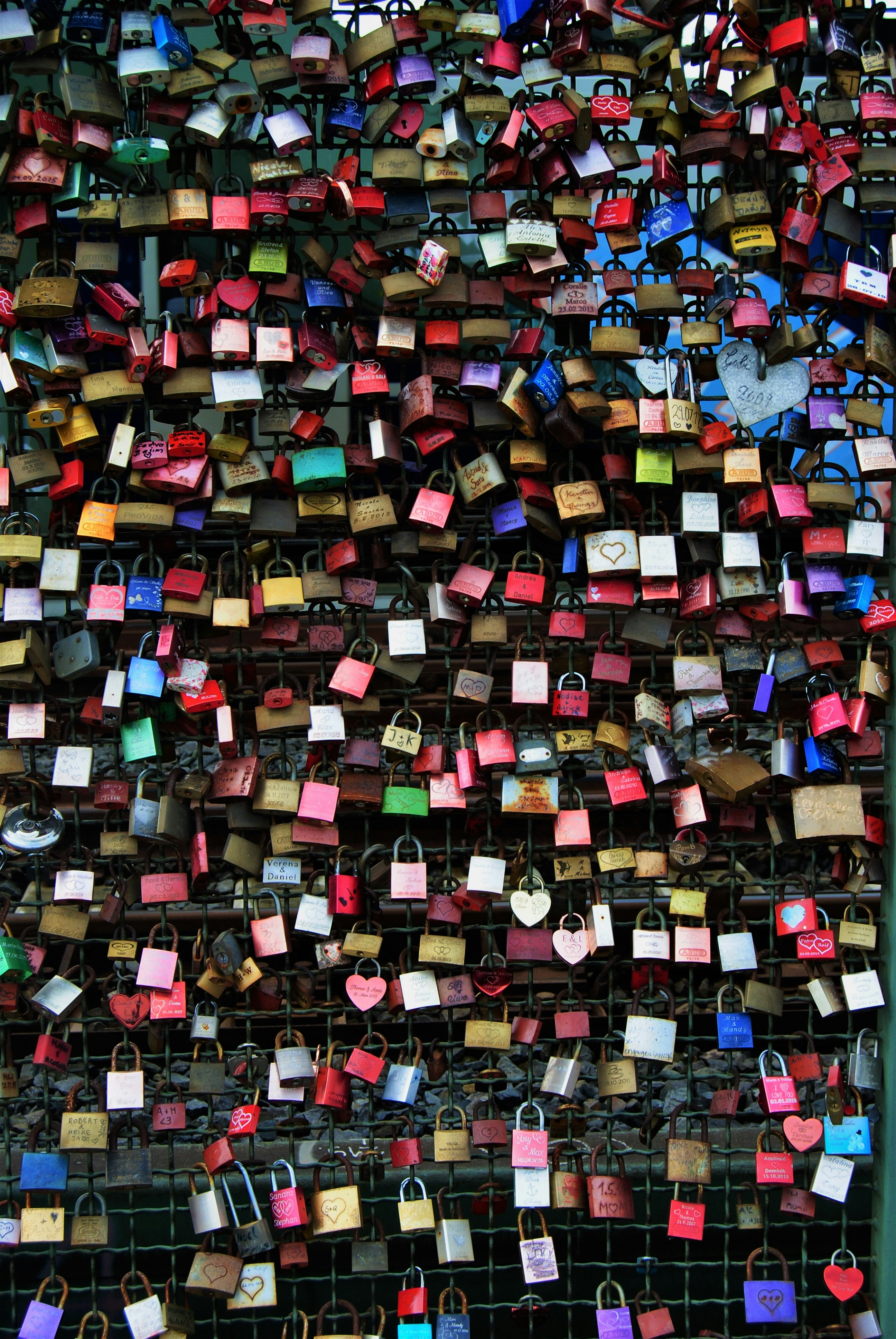 Lockets of Love: A Sea of Colorful Padlocks on a Mesh of Wishes