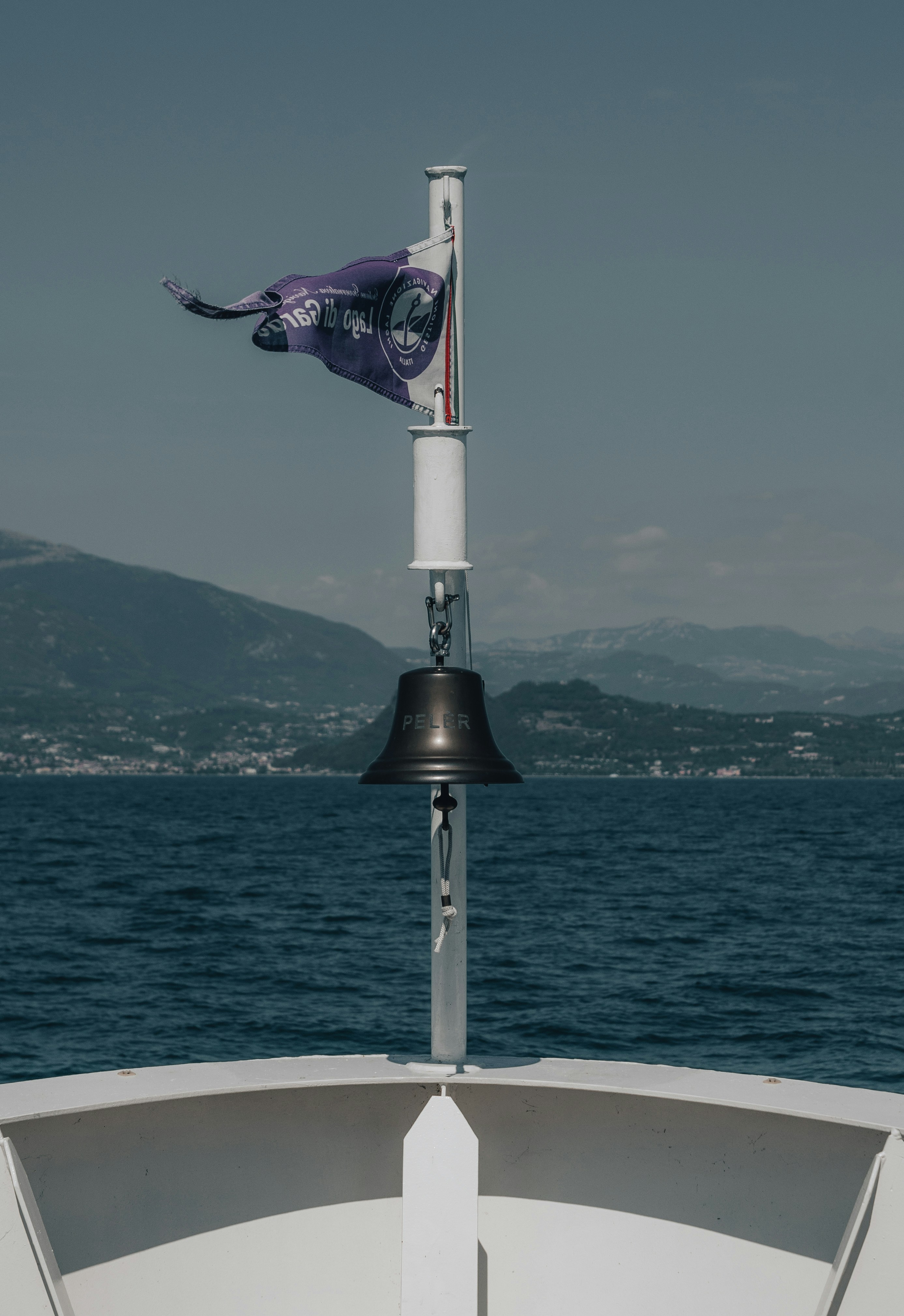 Flag, Bell, and Horizon: A Quiet Vessel at Sea