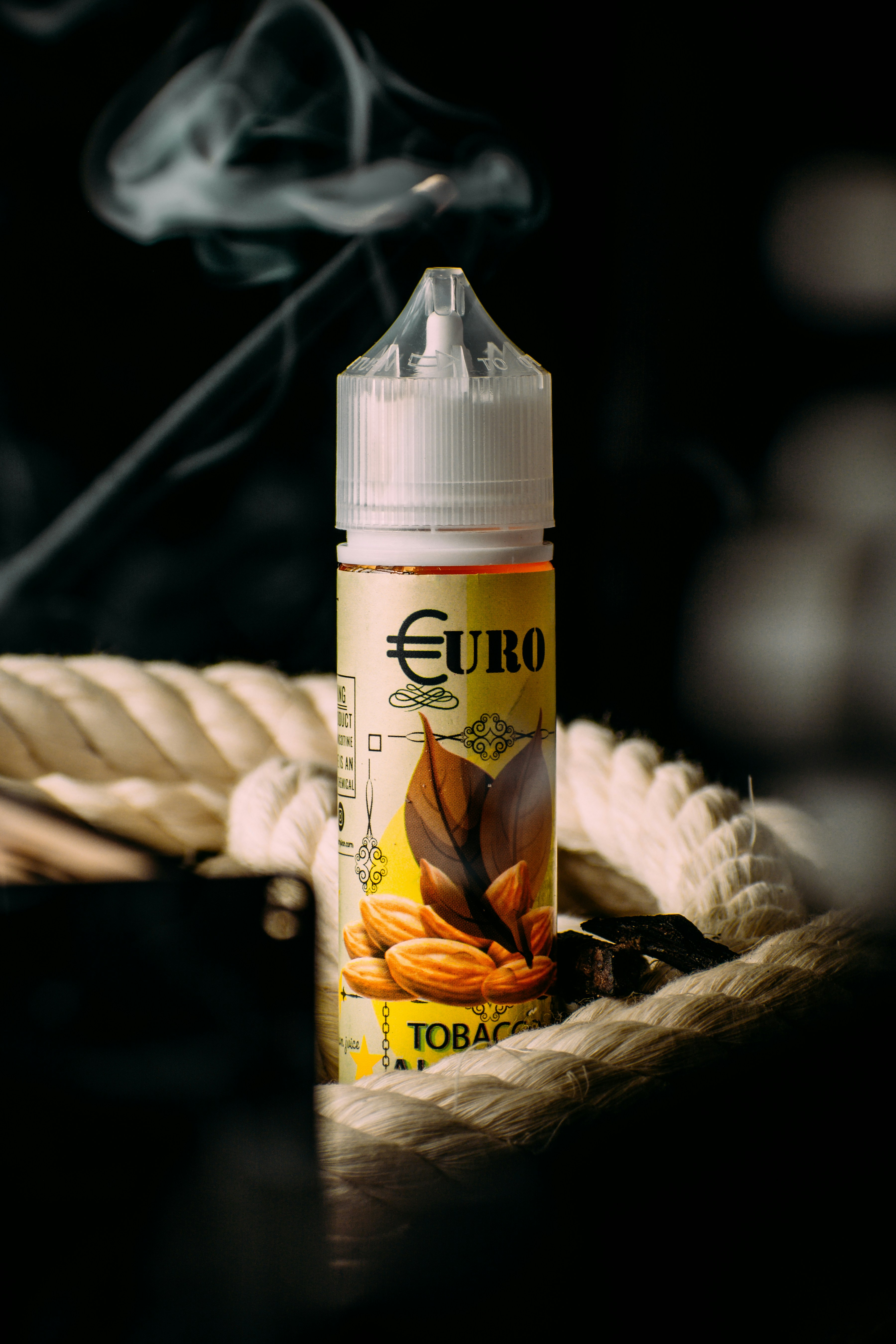 Vape Bottle in Focus: A Quiet Studio Scene with Rope and Smoke