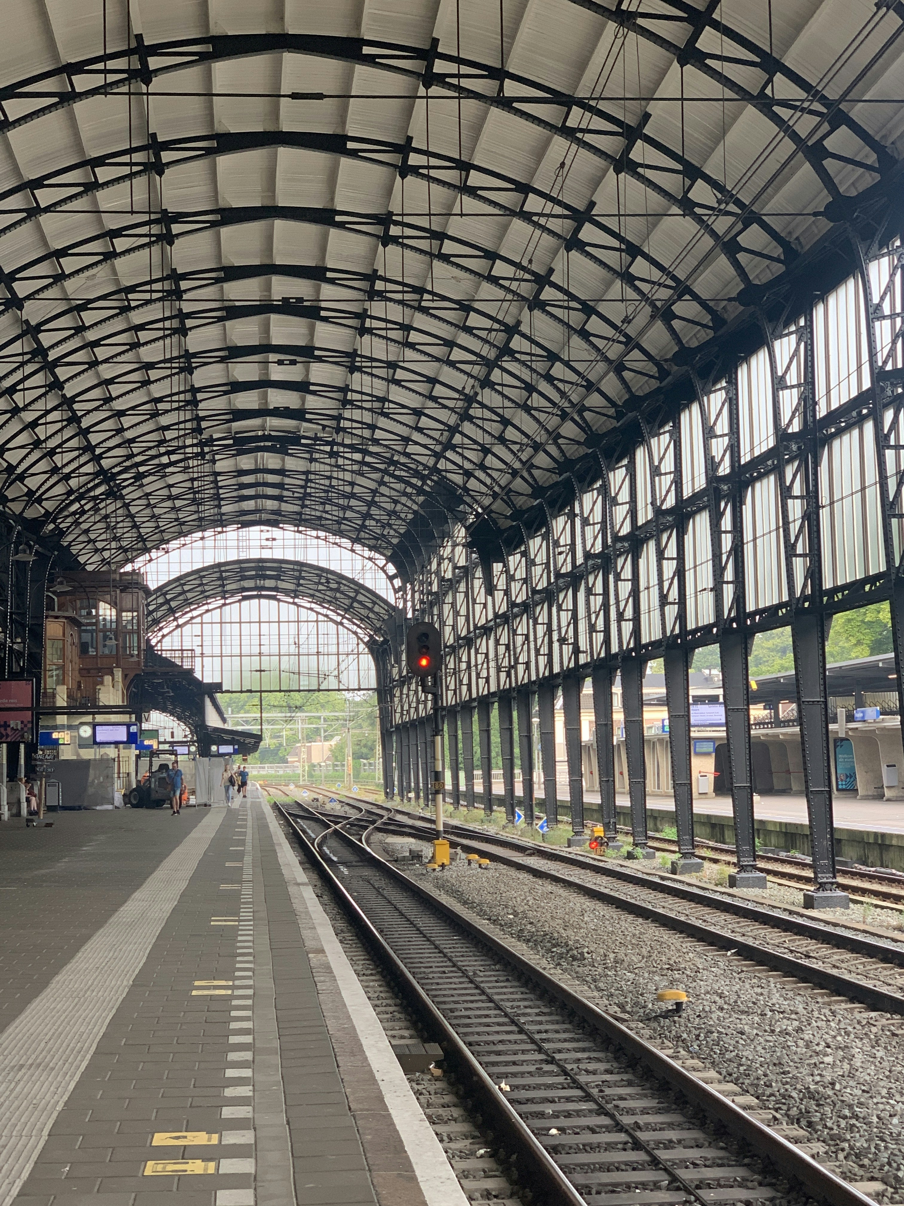 Vanishing Rails Under a Glass-Arch Roof