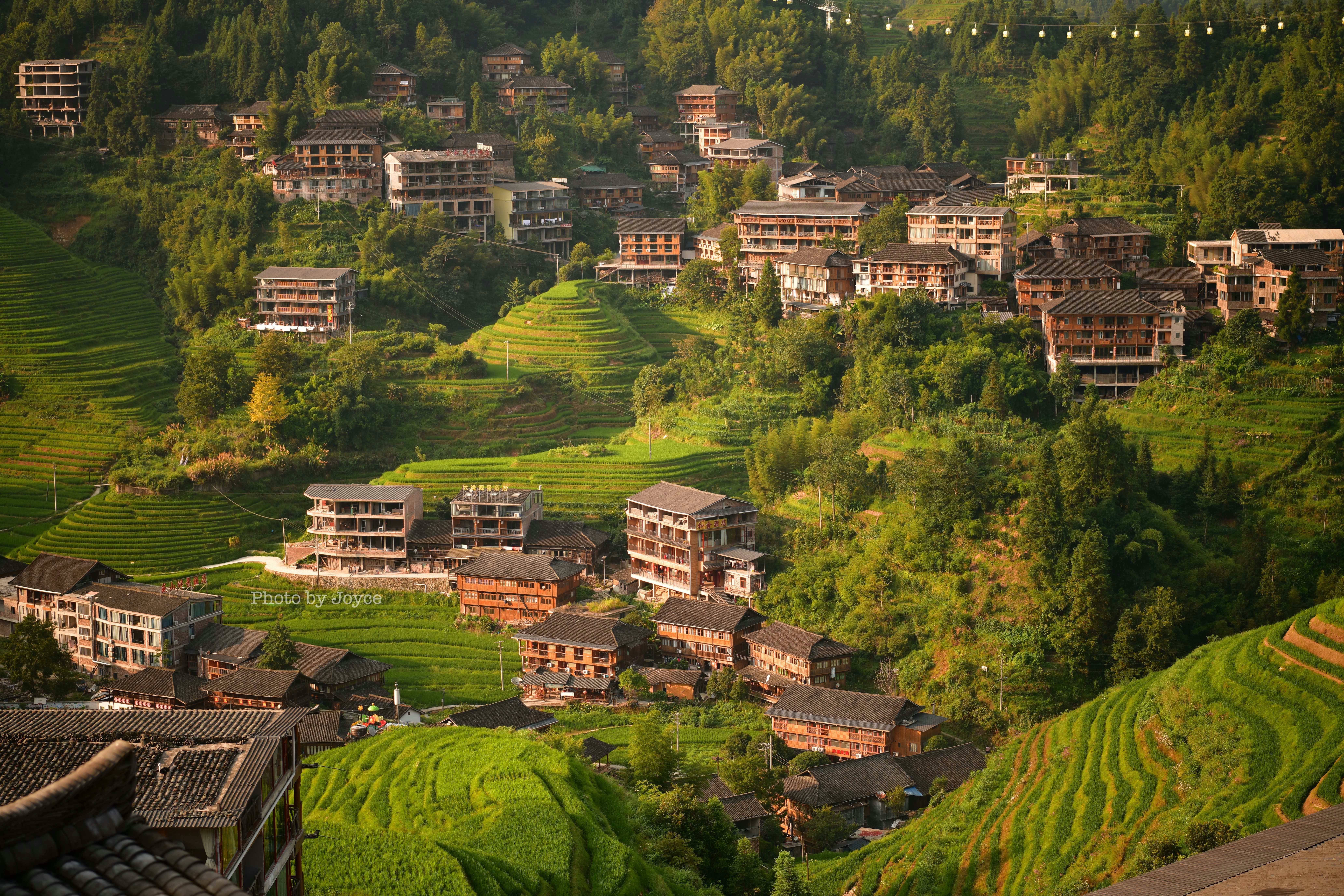 A group of buildings in a wooded area photo – Free Longji rice terrace ...