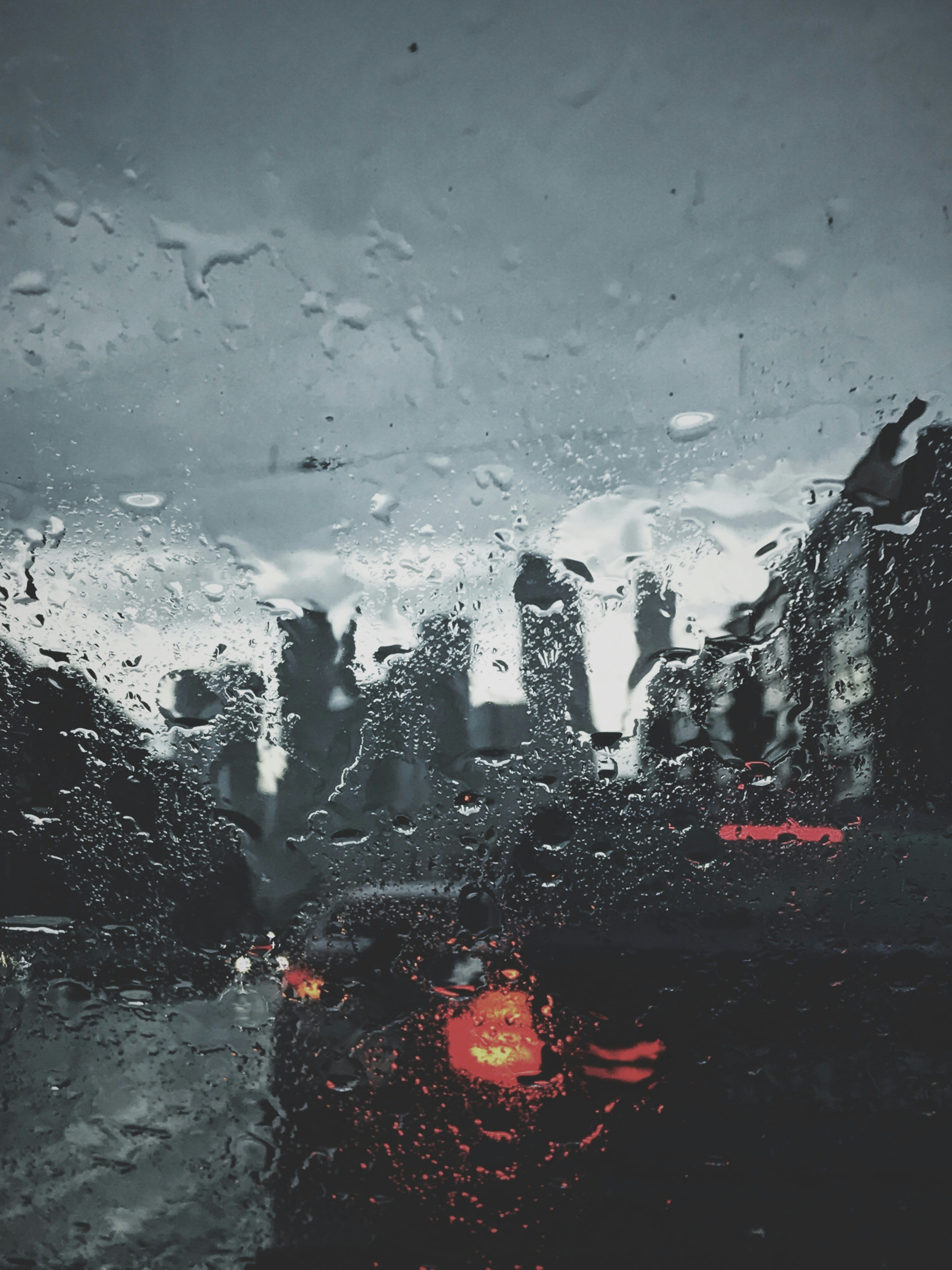 Red Taillights Through a Rain-Slick Window: Urban Night in Blur and Droplets