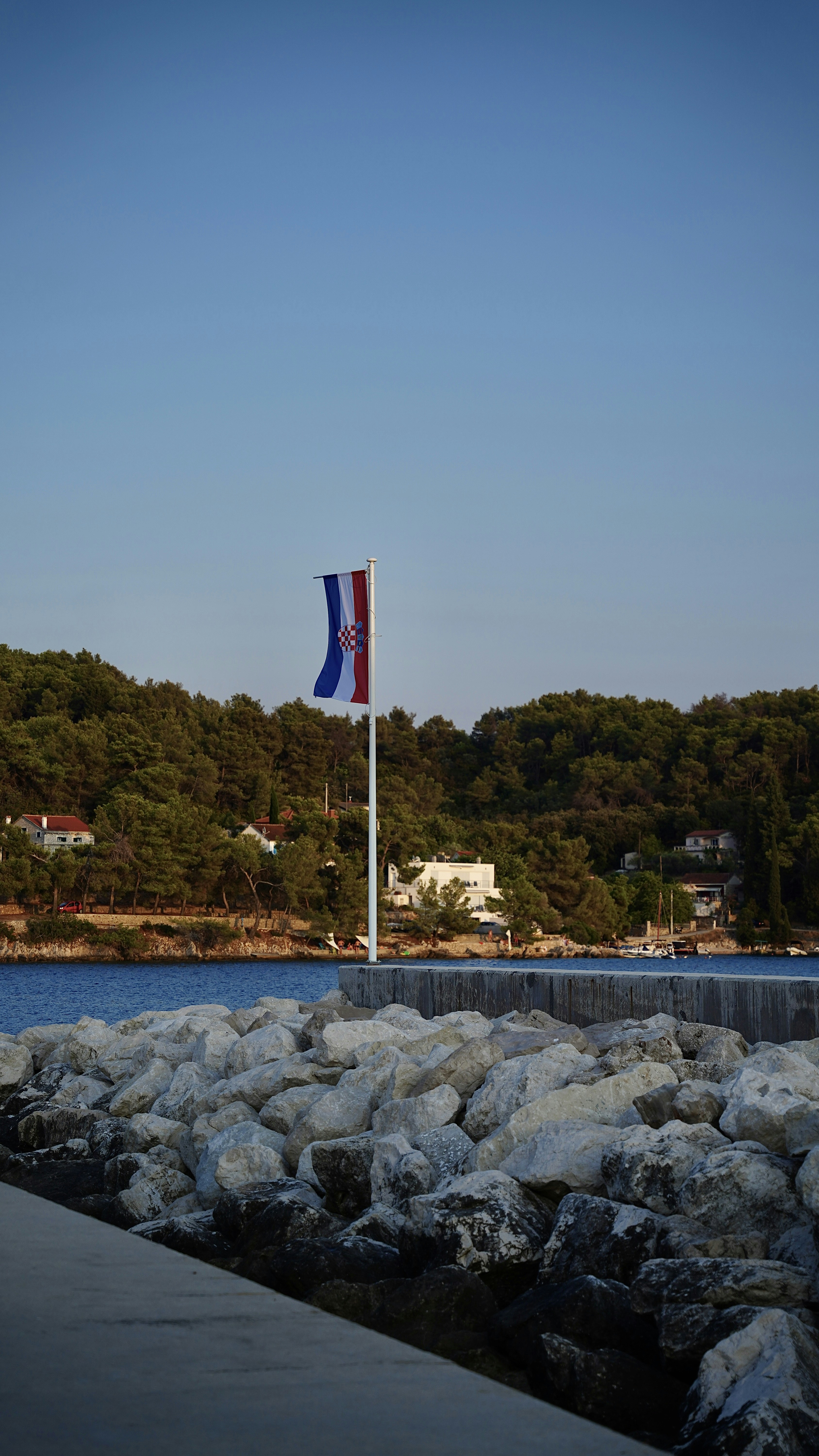Flagpole at the Adriatic Edge: Croatian Colors Rising Over the Breakwater