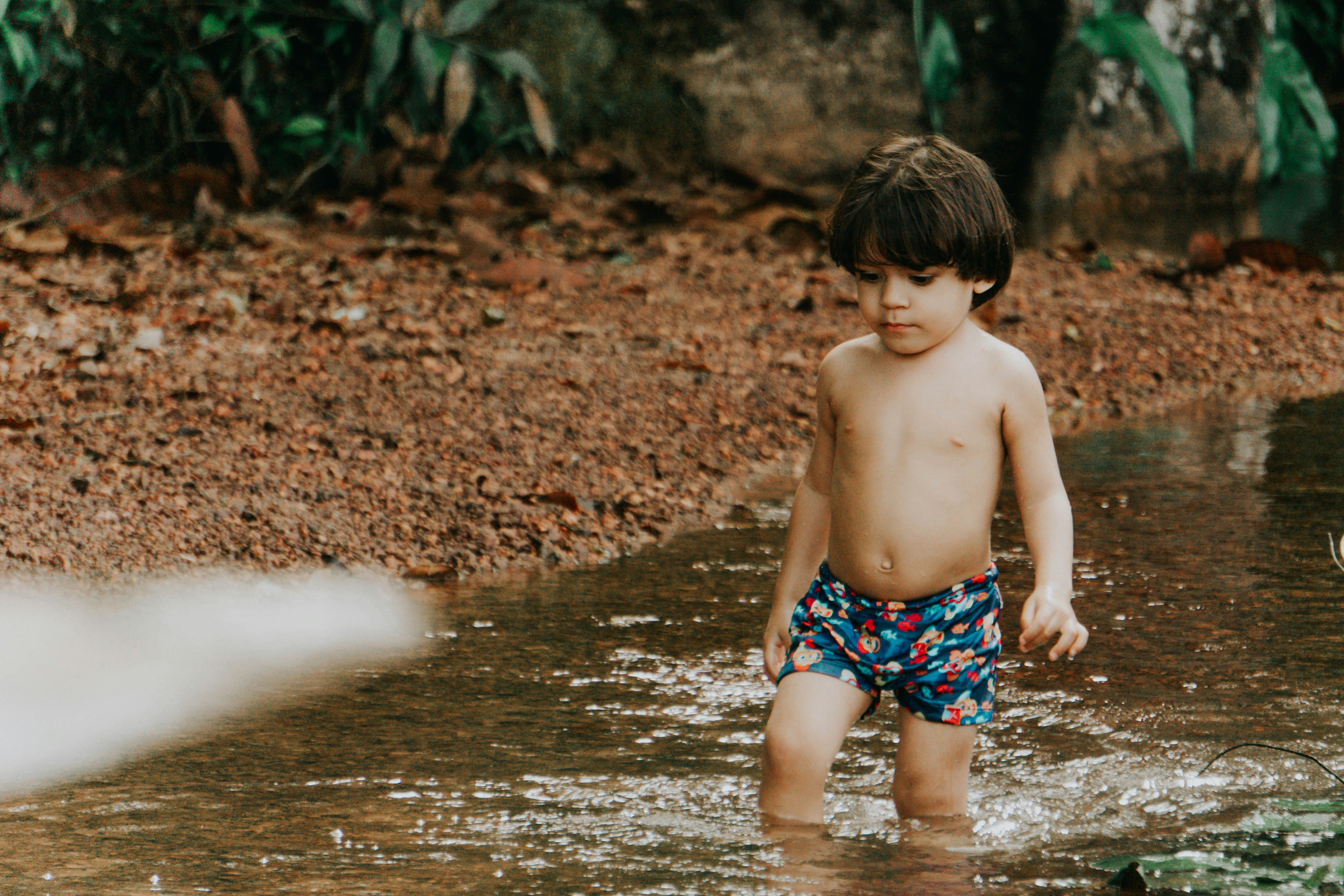 Riverlight Pause: A Small Adventurer Stands in the Shallow Current.