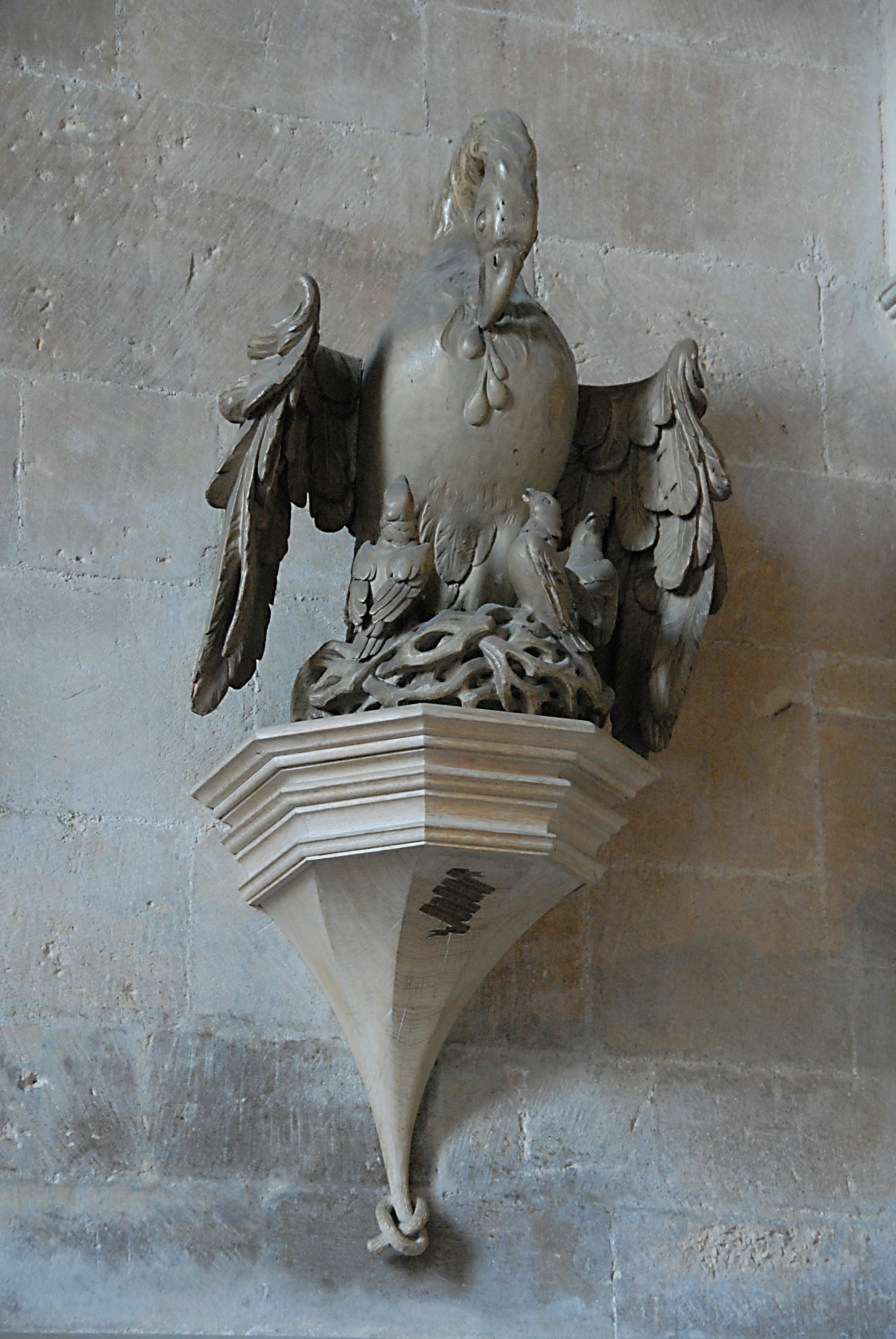 Winged Sentinel on Weathered Stone: Dove Statue Above an Ornate Pedestal