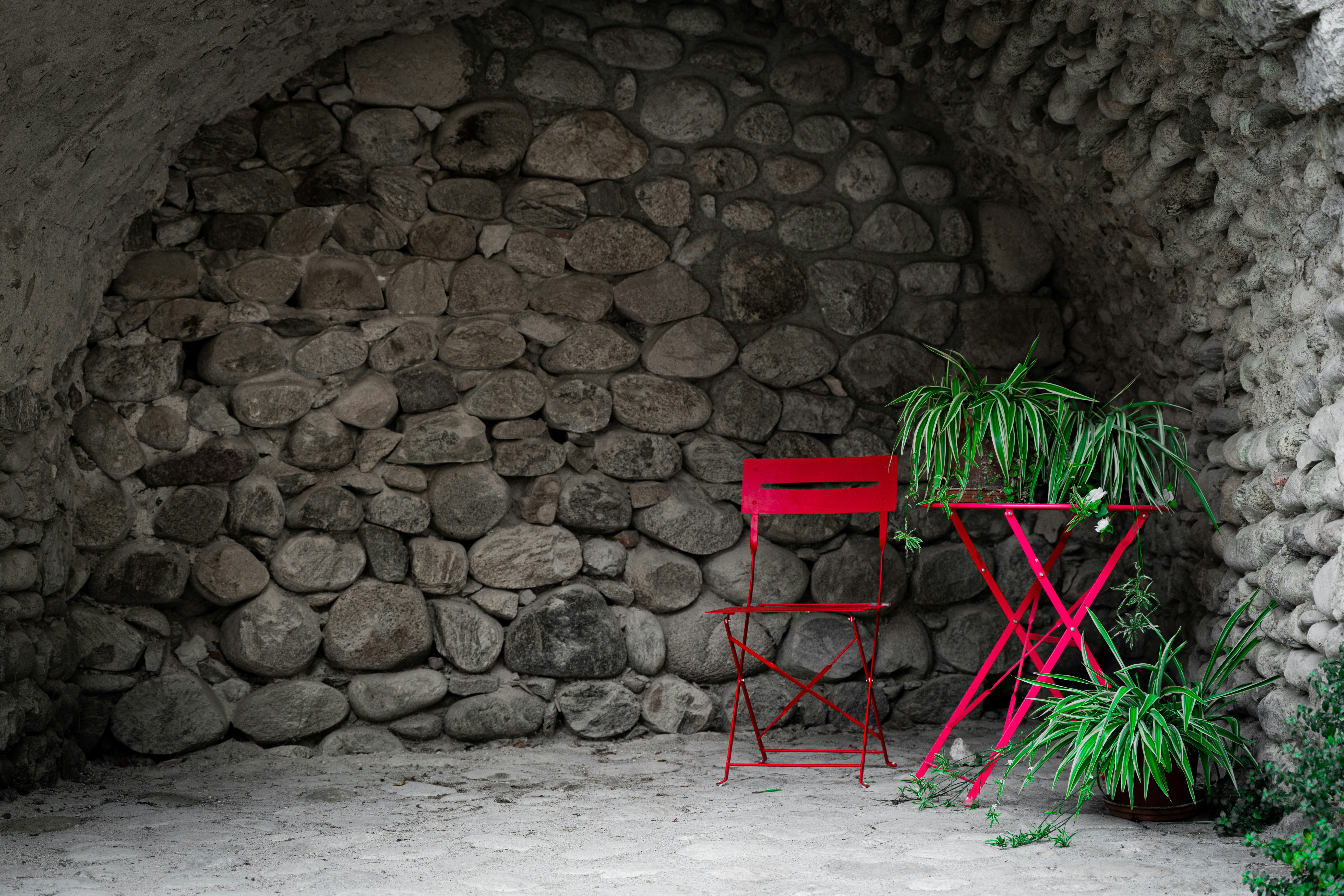Scarlet Chairs in a Stone Alcove: A Quiet Burst of Color