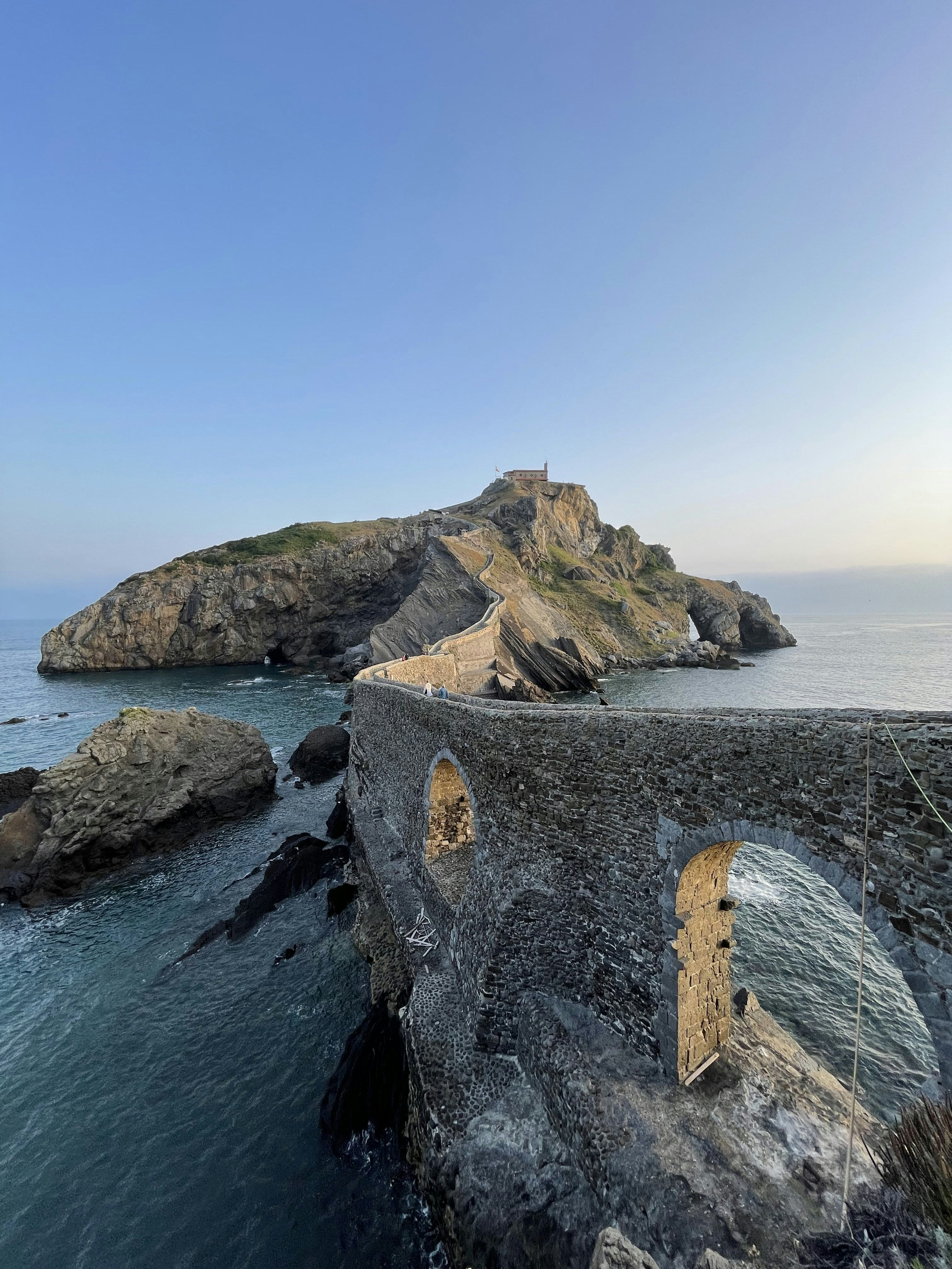 A stone structure on a cliff over the ocean photo – Free Gaztelugatxe ...