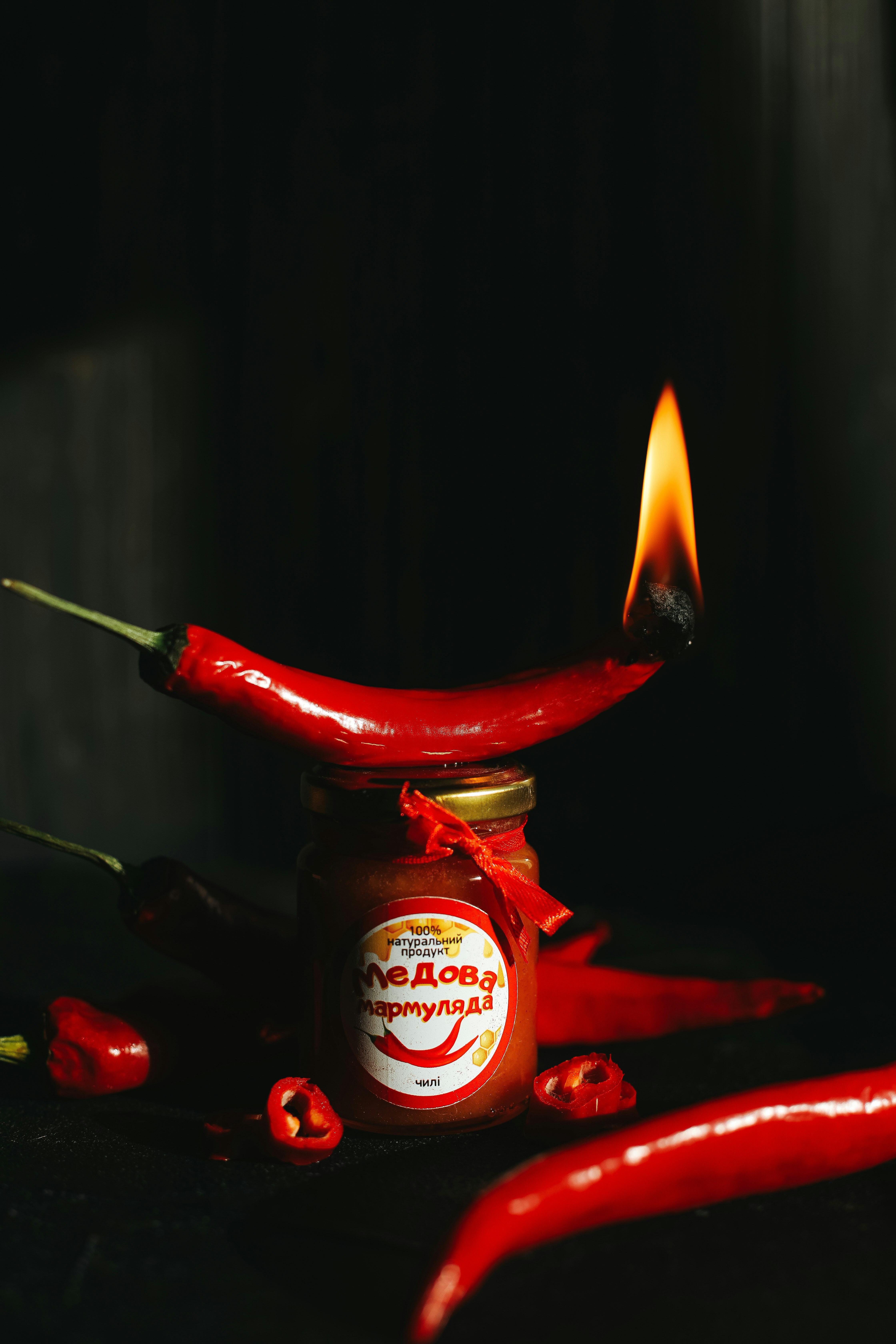 Flame-Speckled Chili Perches Over a Jar: A Quiet Still-Life of Heat and Glow