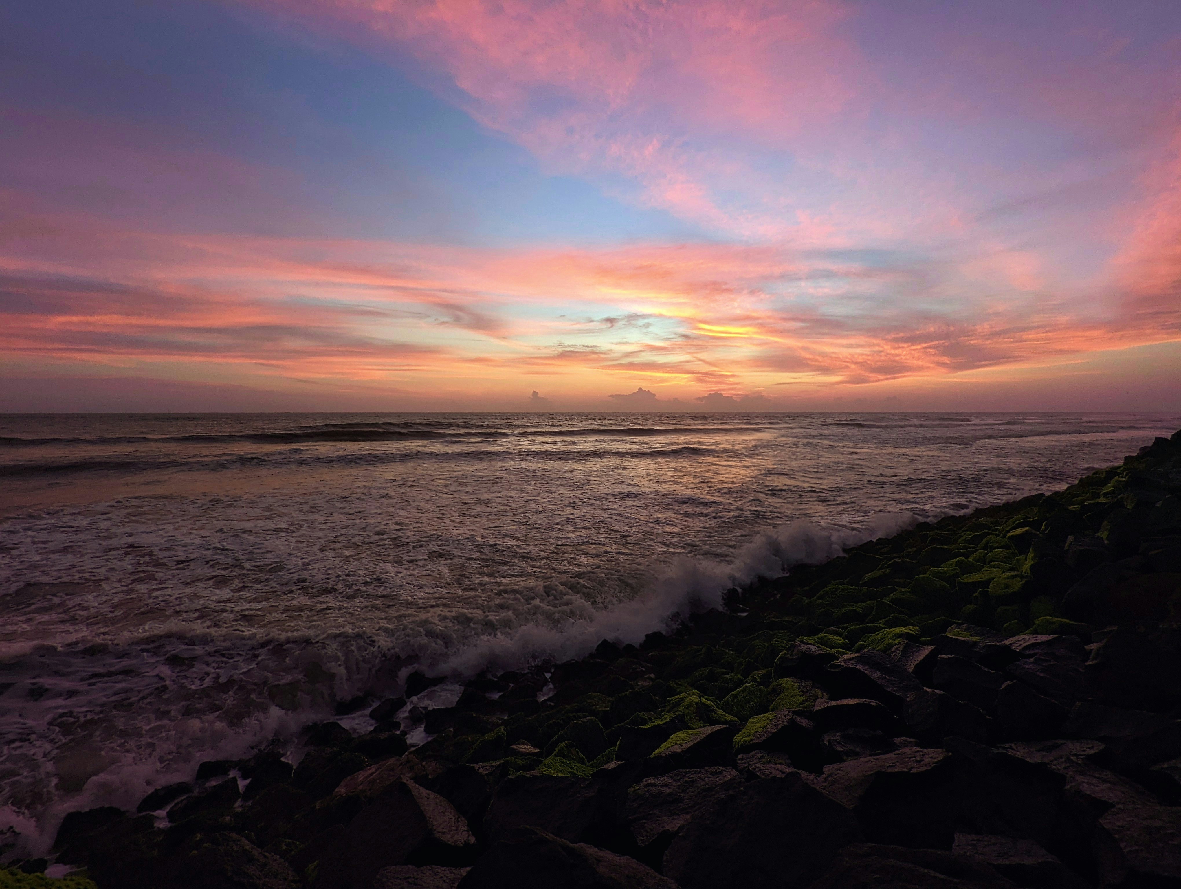 Crimson Horizon Over a Mossy Breakwater