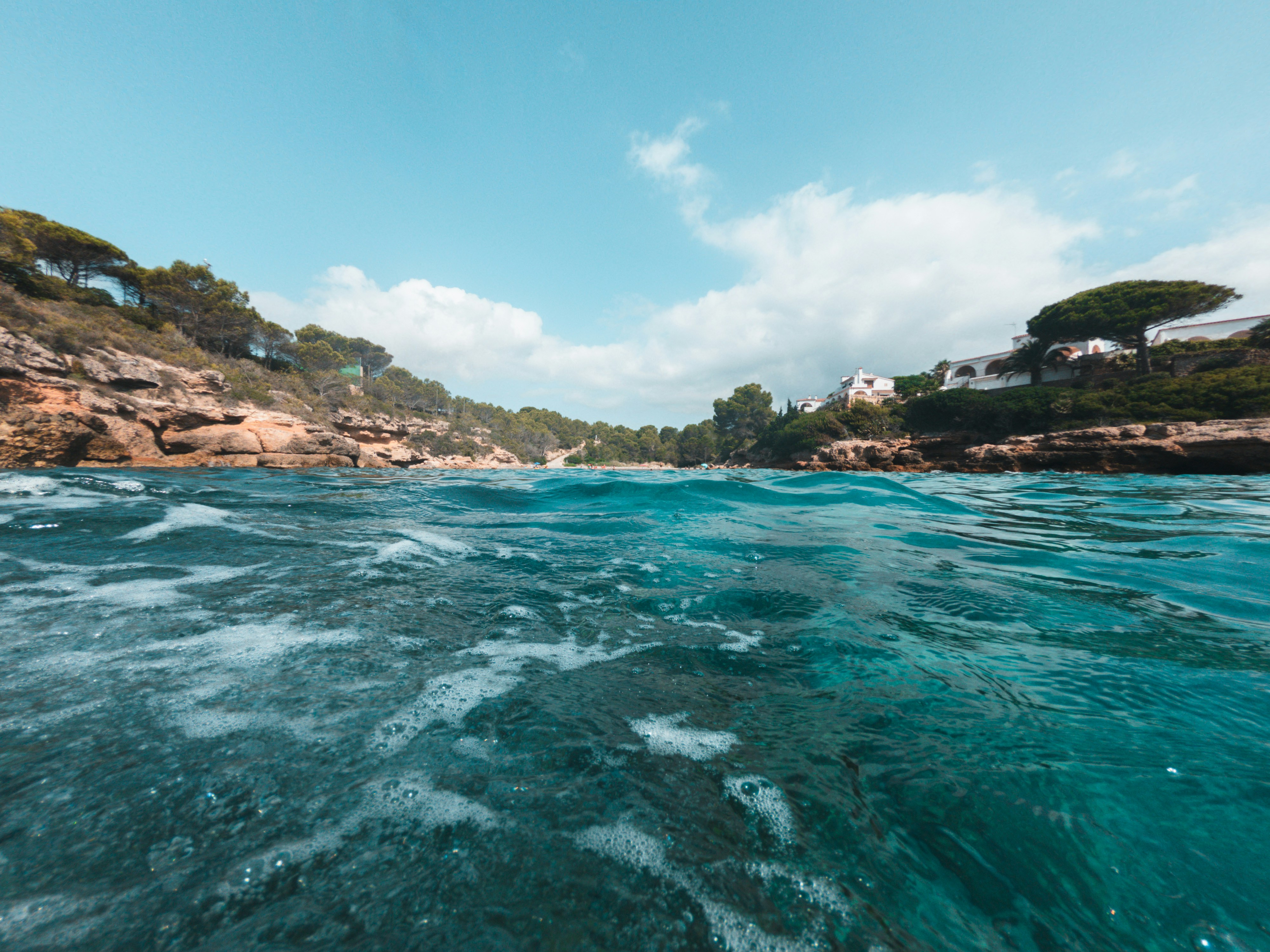 A body of water with rocks and trees on the side photo – Free Calafat ...