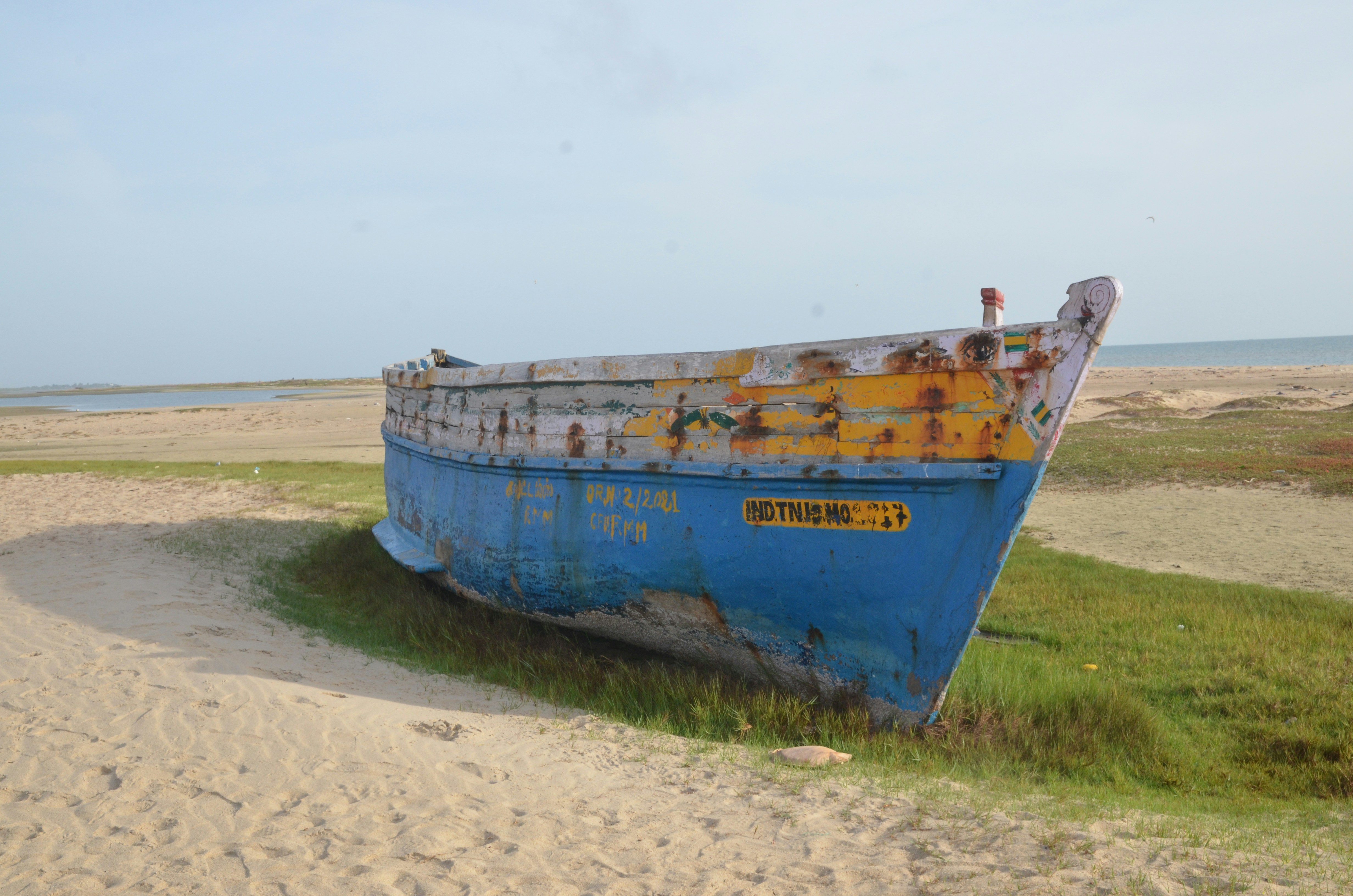 Weathered Blue Hull Adrift on a Quiet Beach