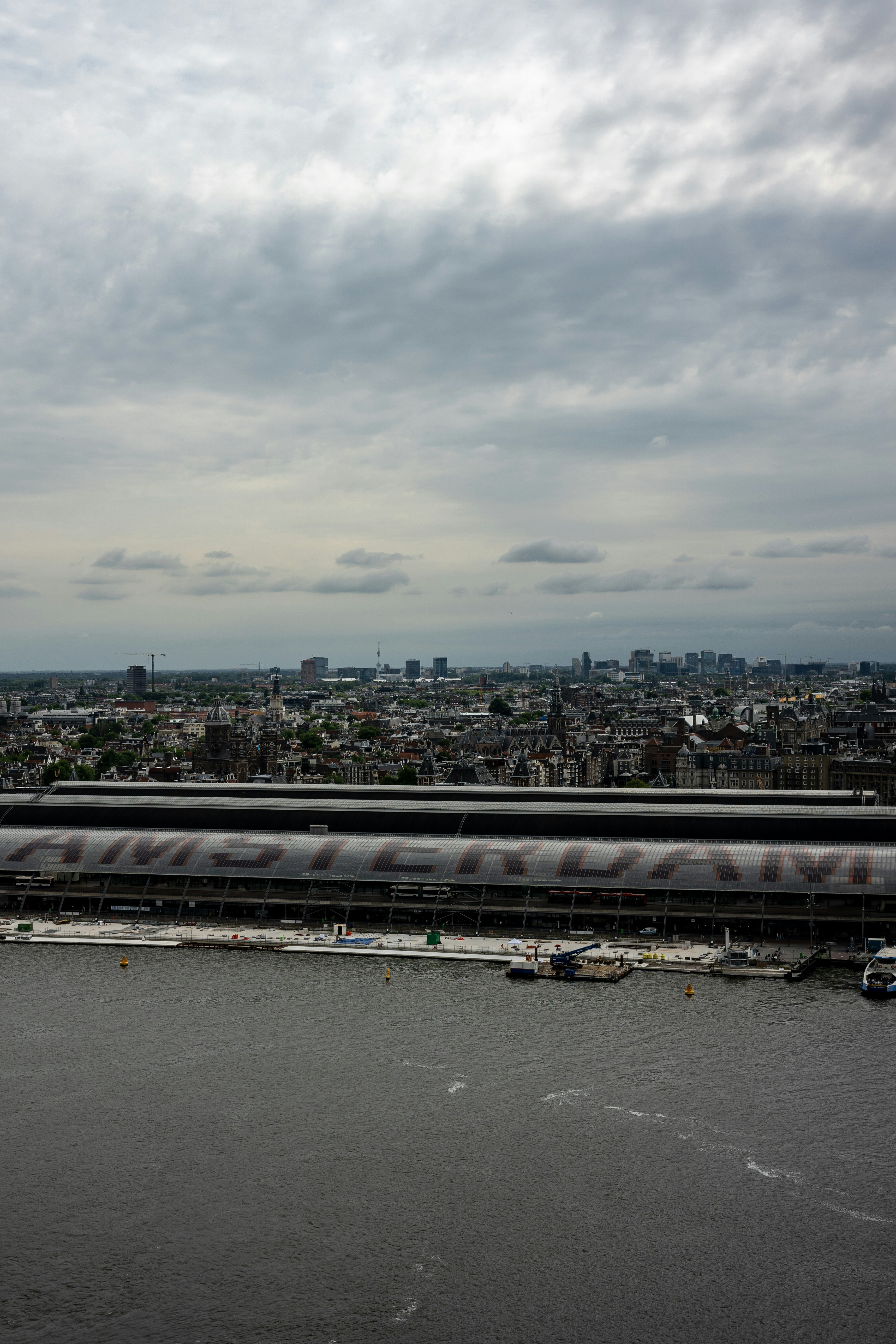 Riverside Glass Canopy: A Cityscape Under Clouded Light