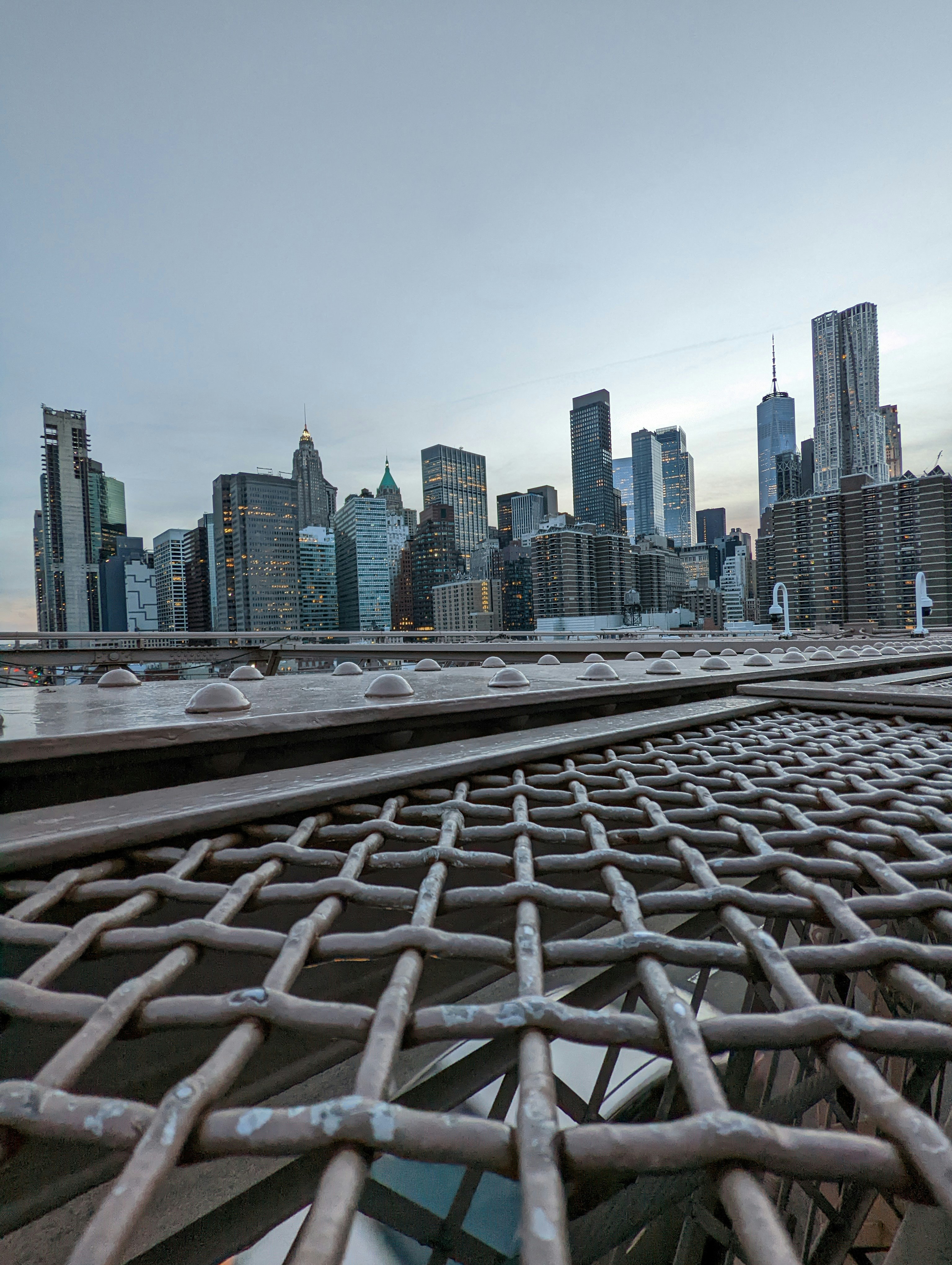 Rusted Mesh, Glass Giants: A Low-Angle Manhattan Vista