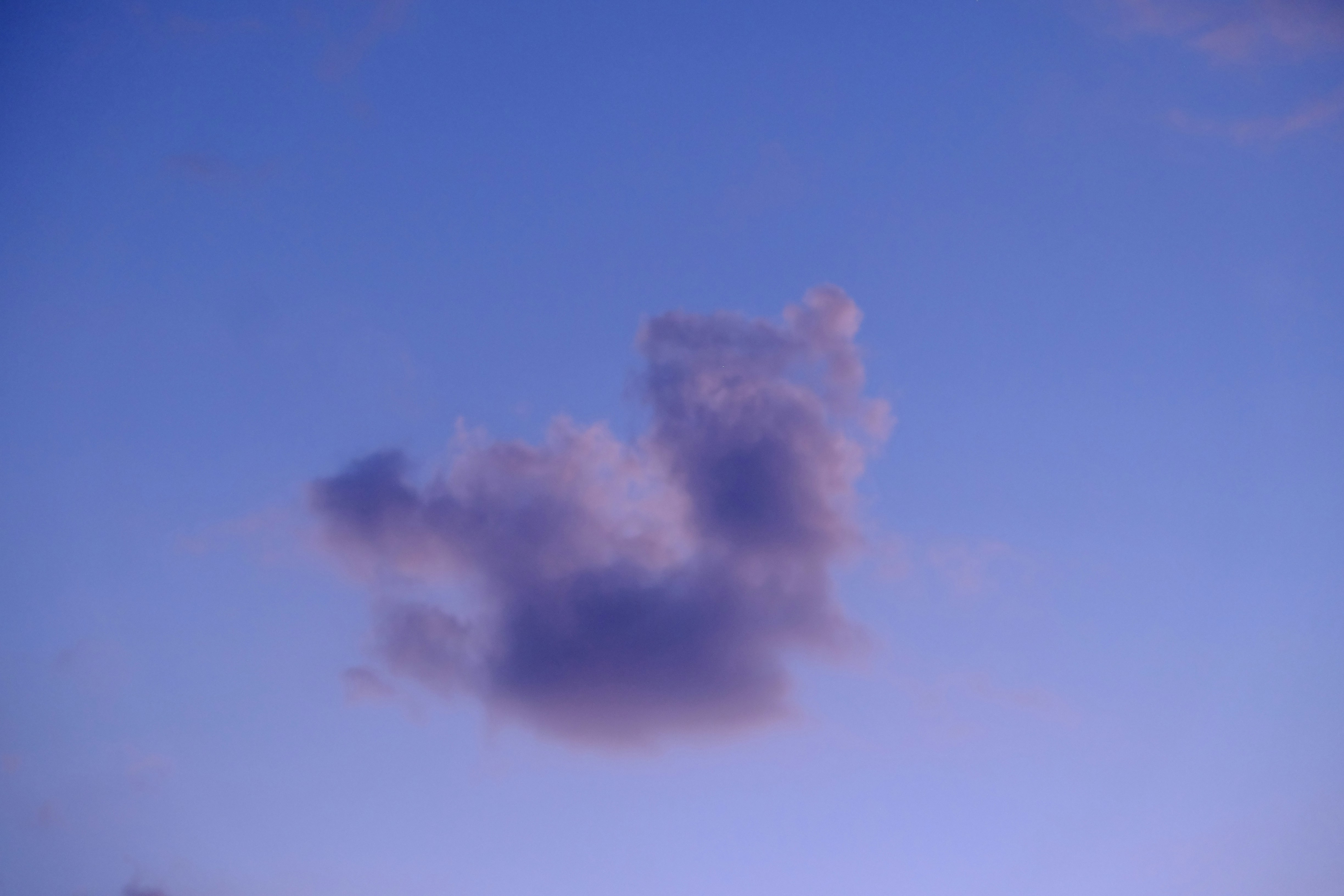 A playful cloud resembling a creature floats in a pastel twilight sky, casting soft shadows against the fading light.