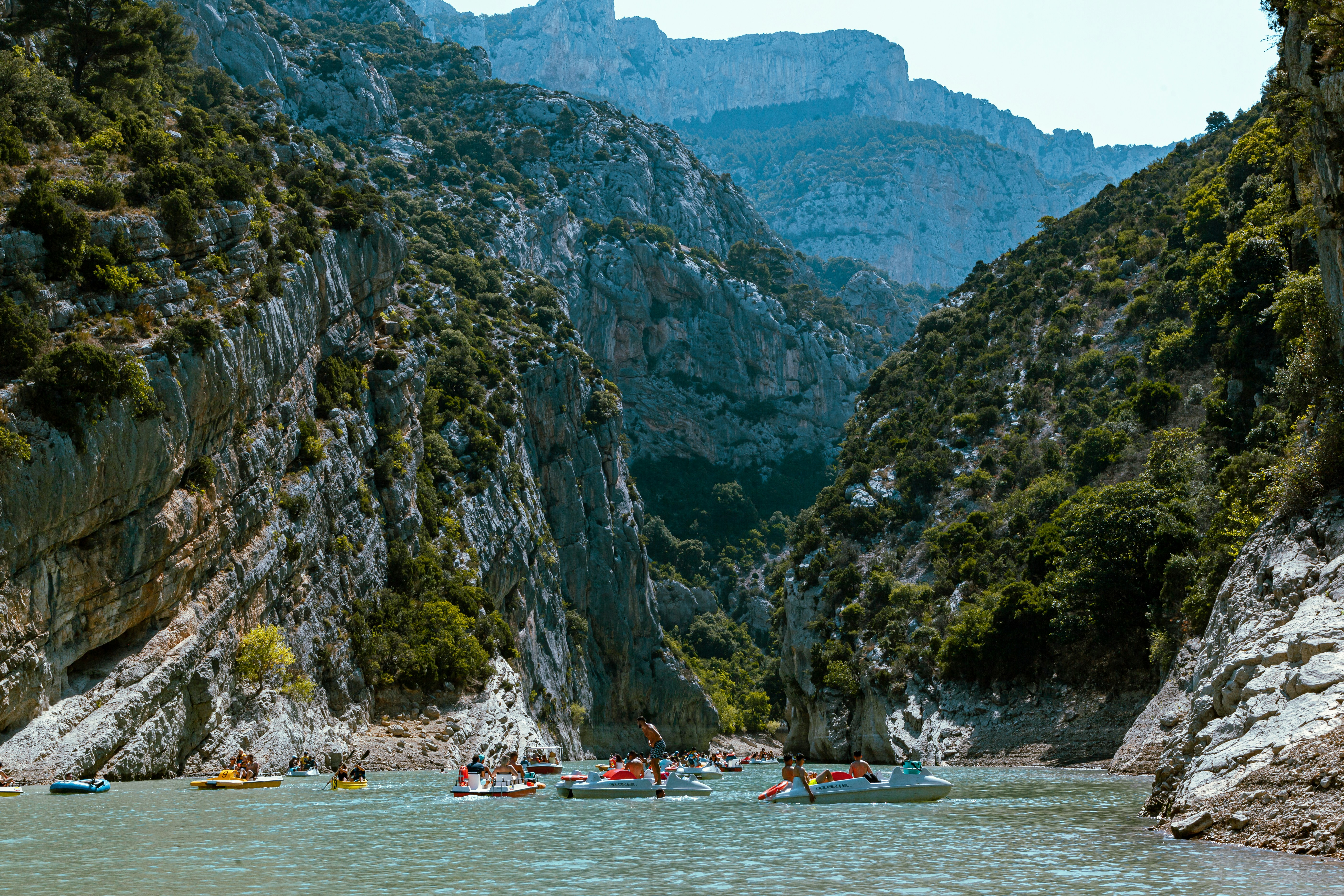 A group of people in kayaks in a river between rocky cliffs photo ...