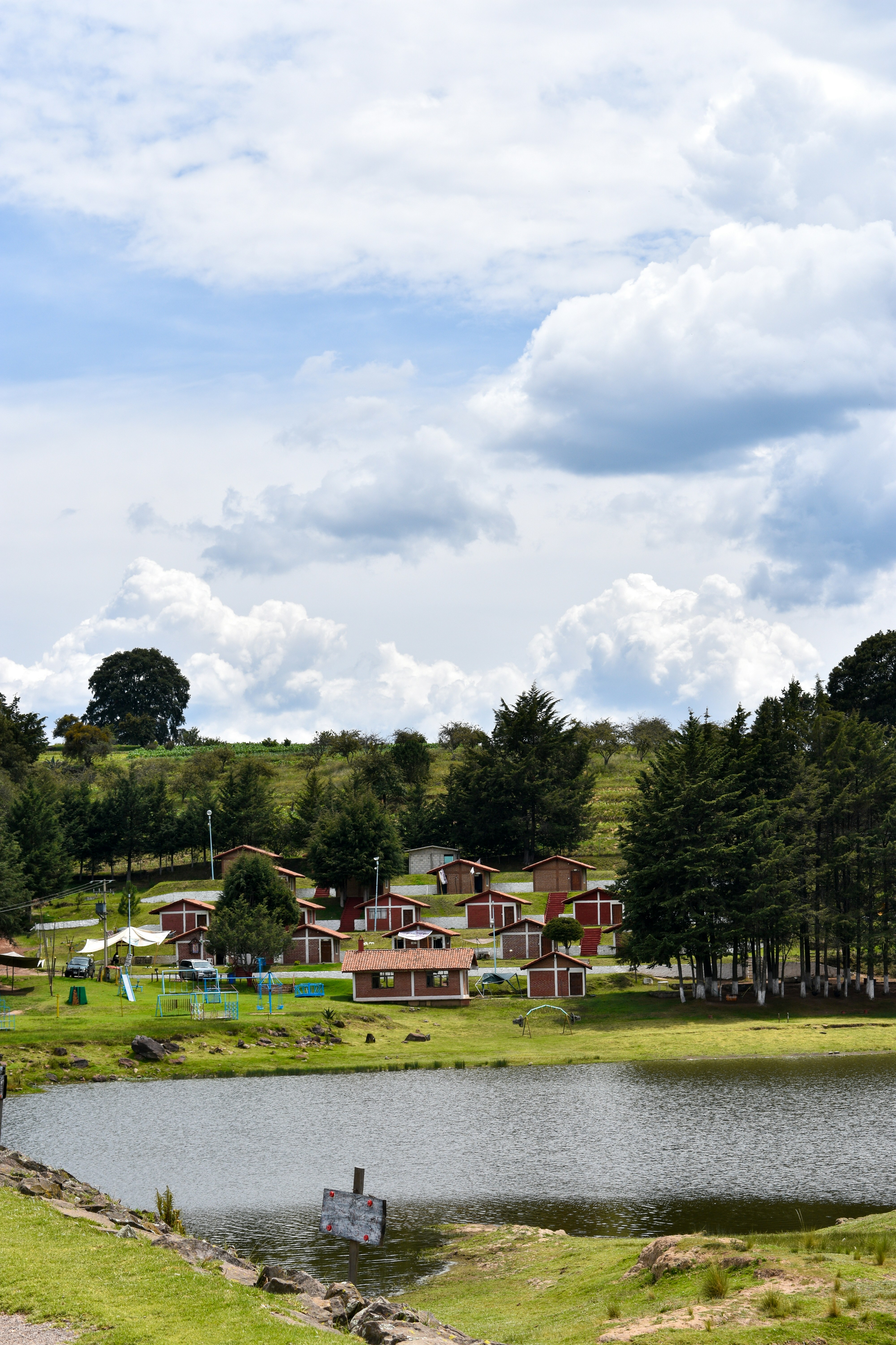 Lakeside Row of Red Cabins Under a Cloud-Filled Sky