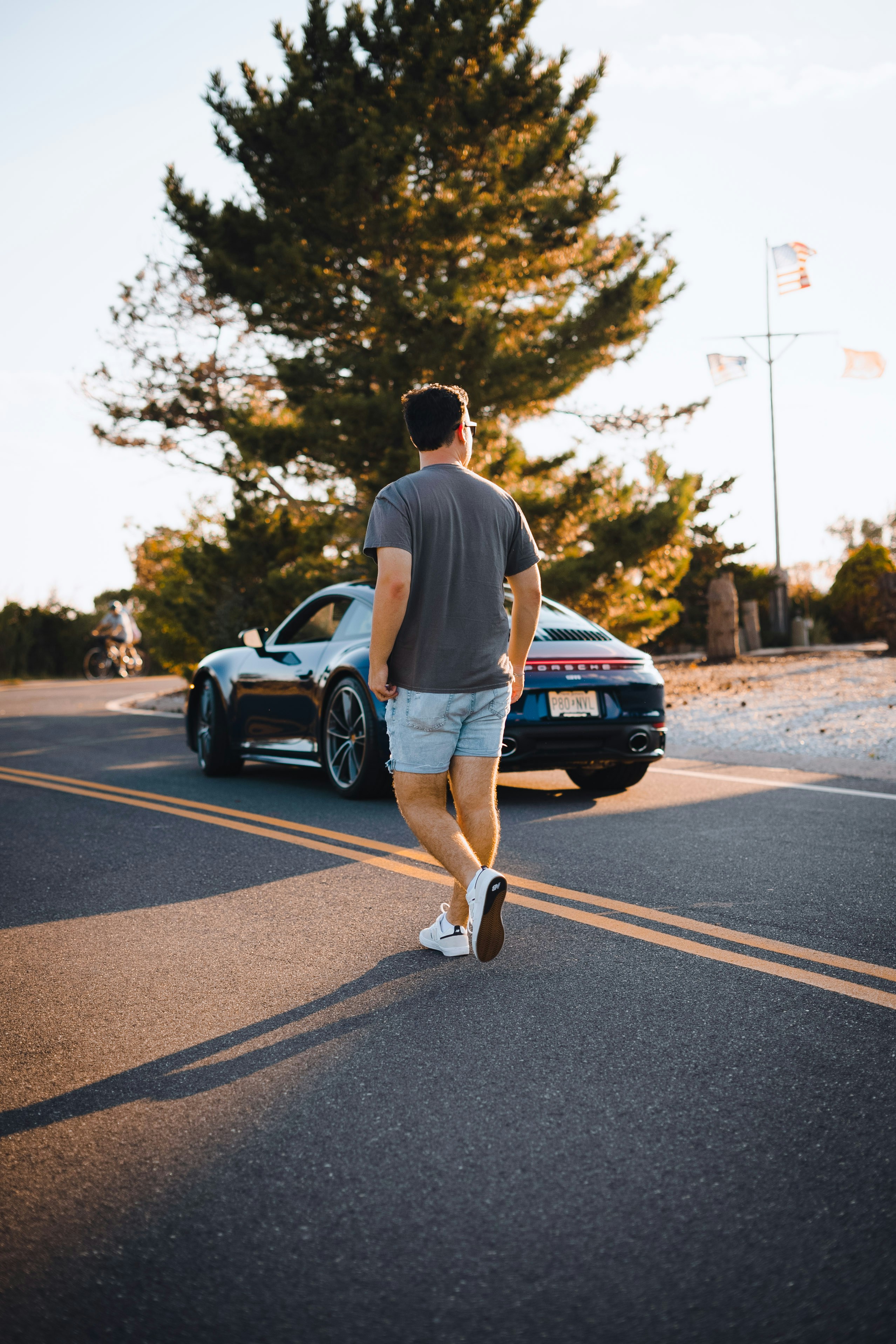 Golden Hour Convergence: A Pedestrian Heads Toward a Porsche on an Open Road