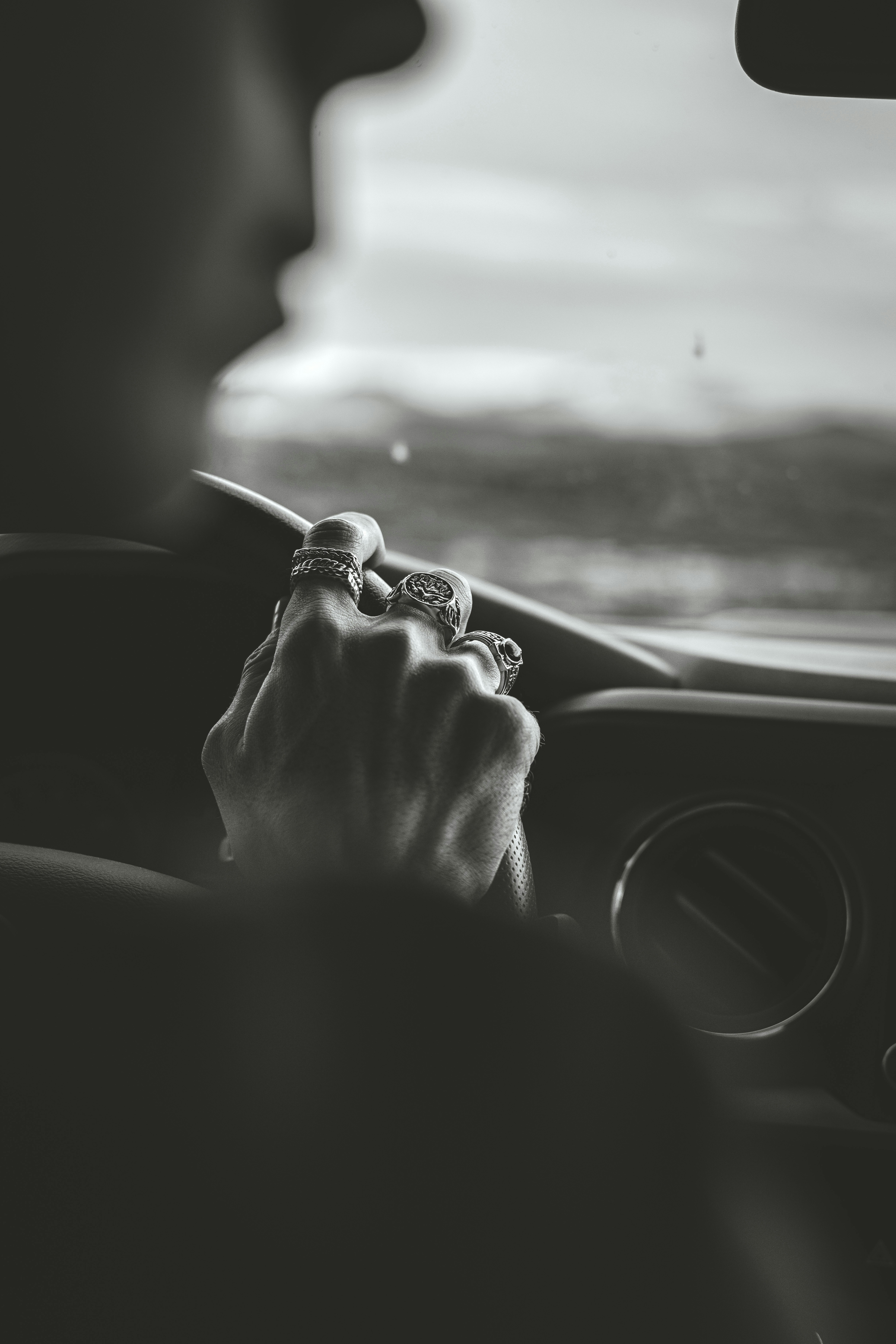 Rings on the Wheel: A Monochrome Moment in the Driver's Cockpit