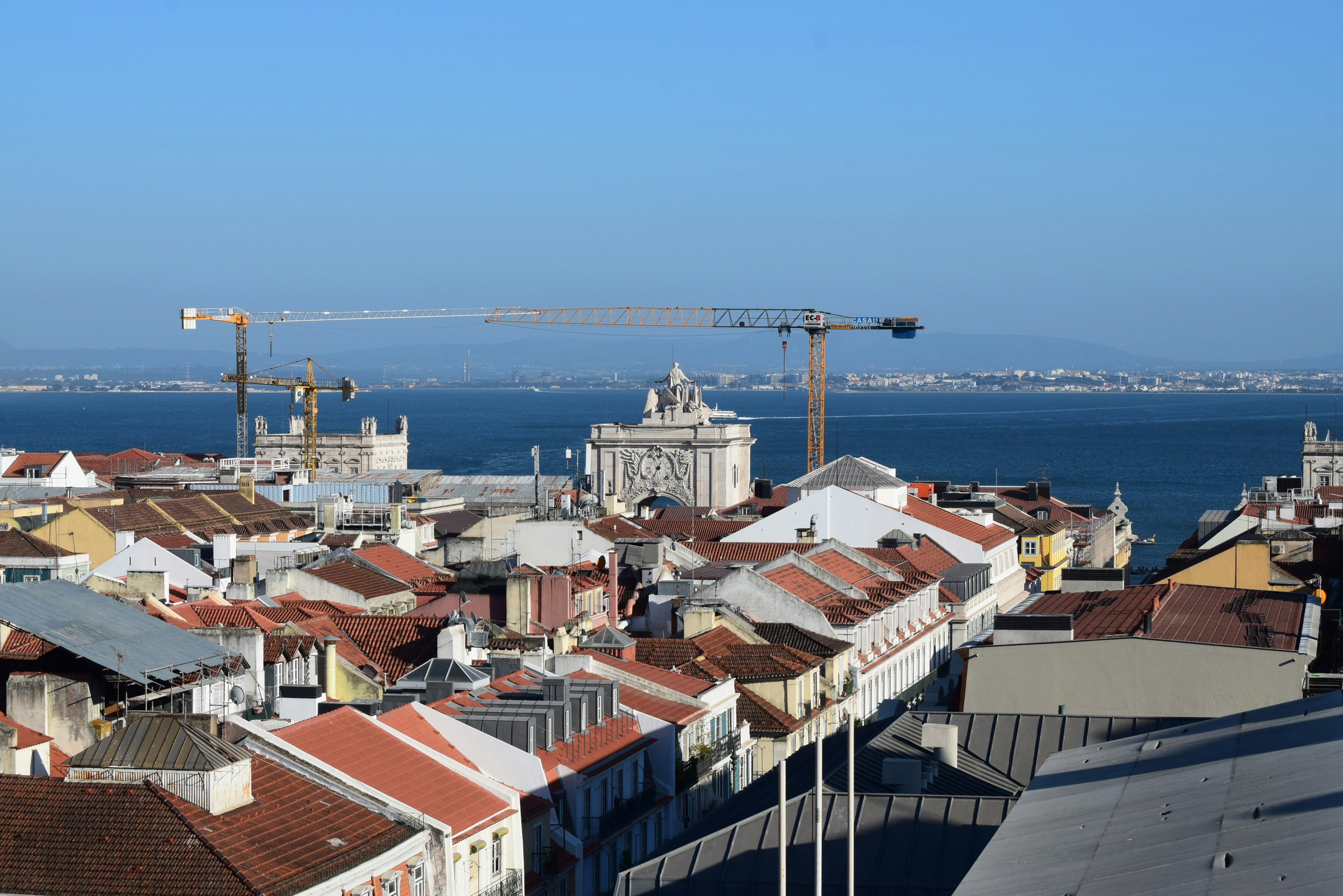 Crane Horizon over Terracotta Rooftops Along the Waterfront