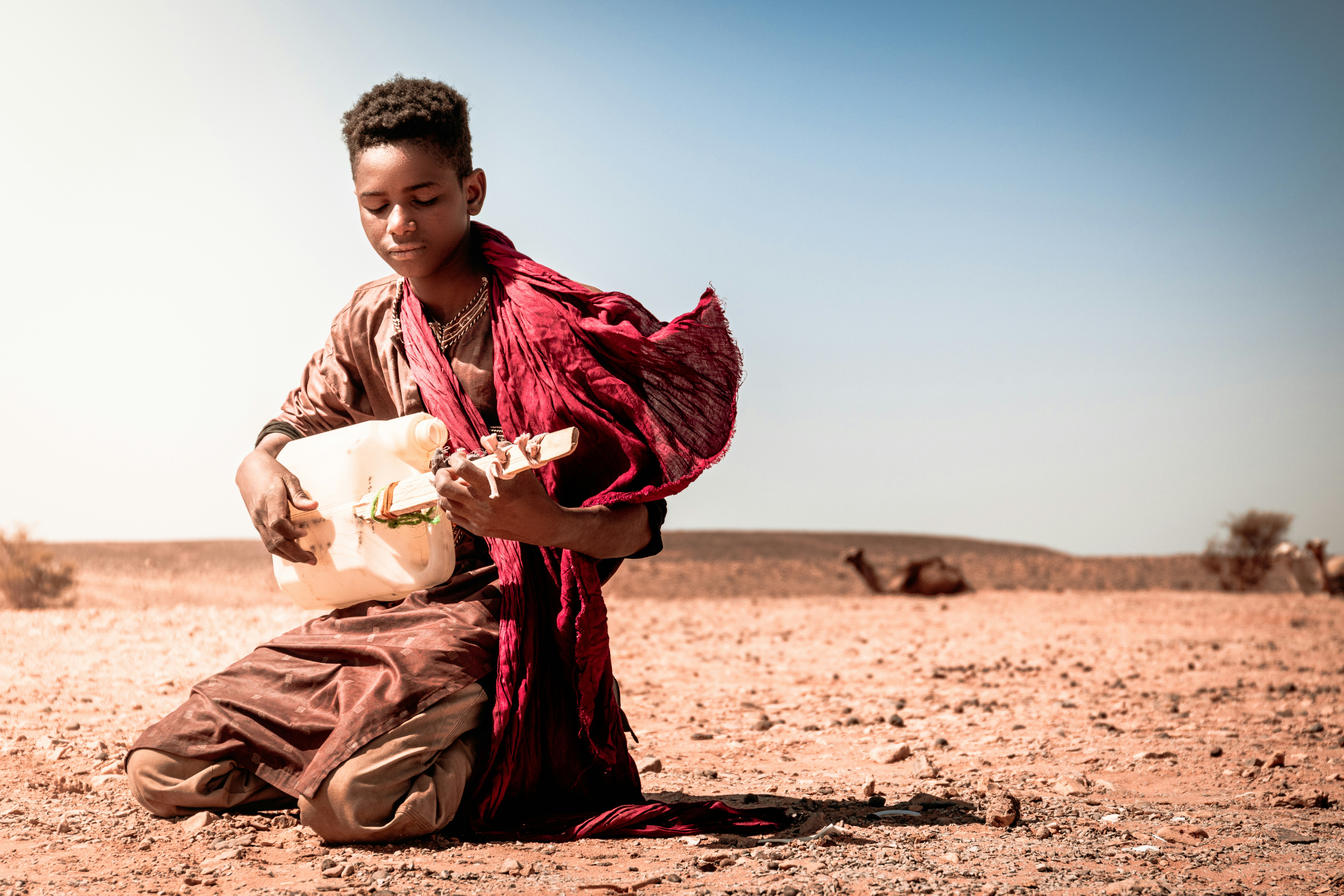 small boy from Timokten Algerian sahara playing his custom instrument