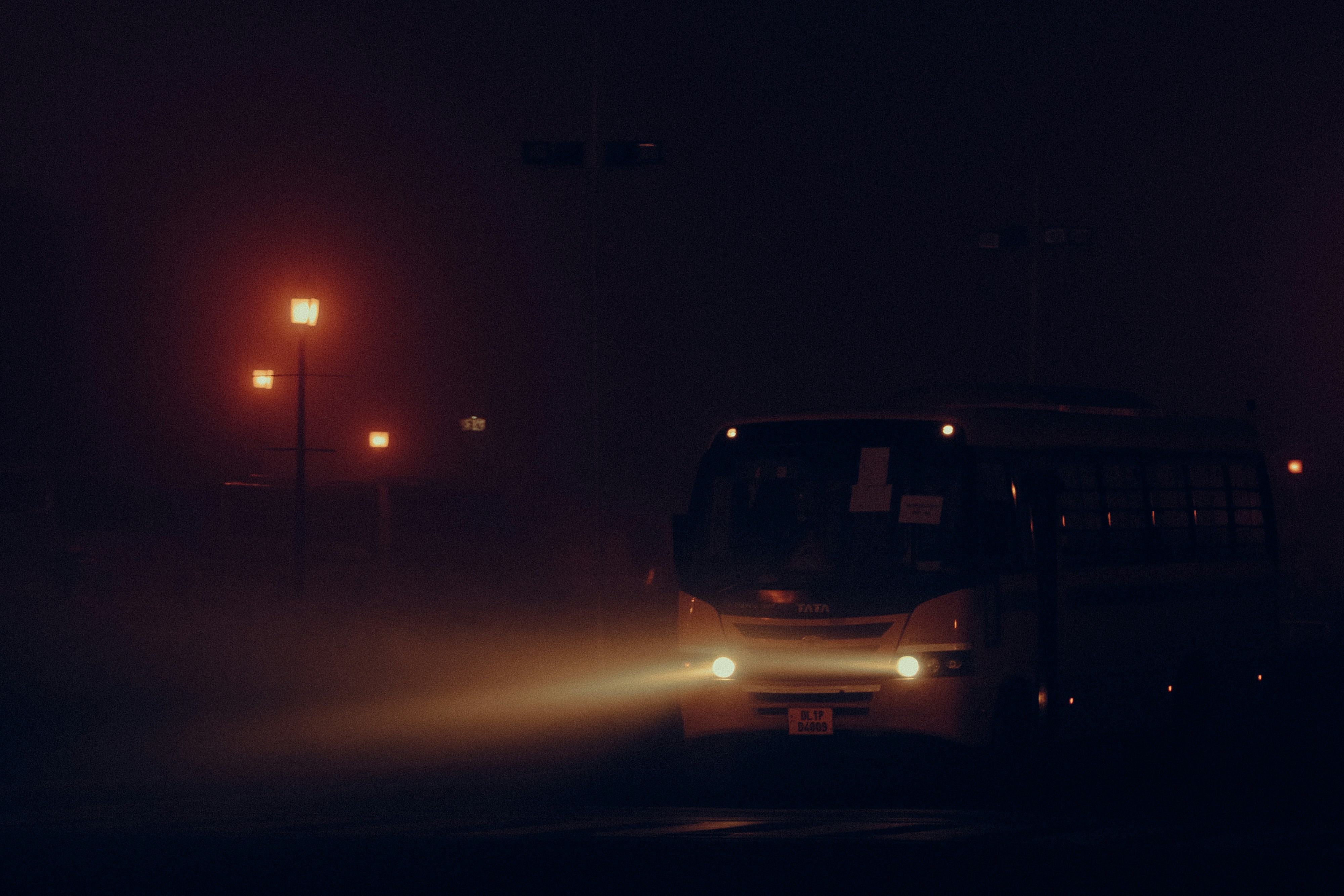 Amber Beacon Through Night Fog: The Bus Front in Dim Streetlight Gloom