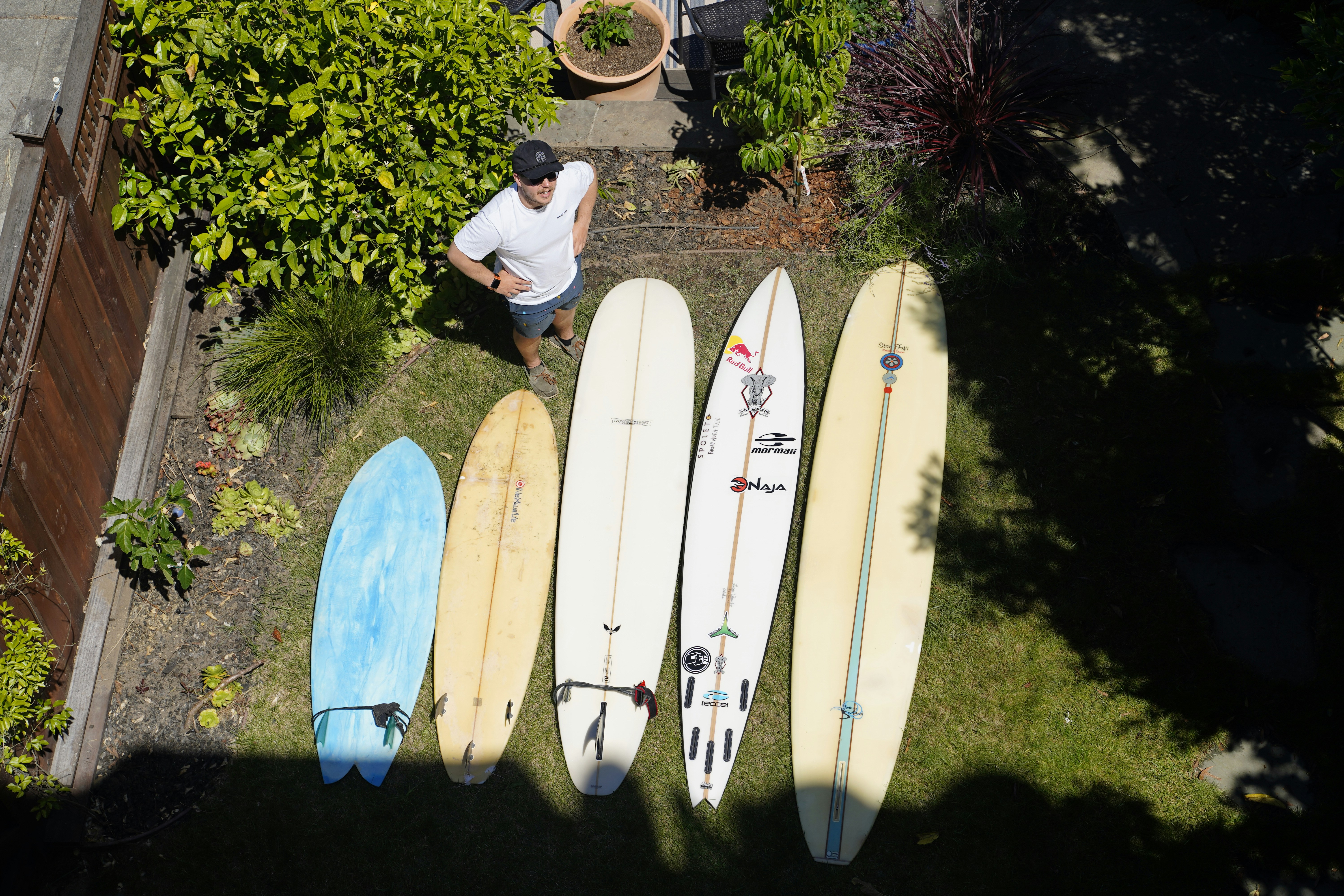 Una persona sentada junto a varias tablas de surf foto – Imagen de San ...