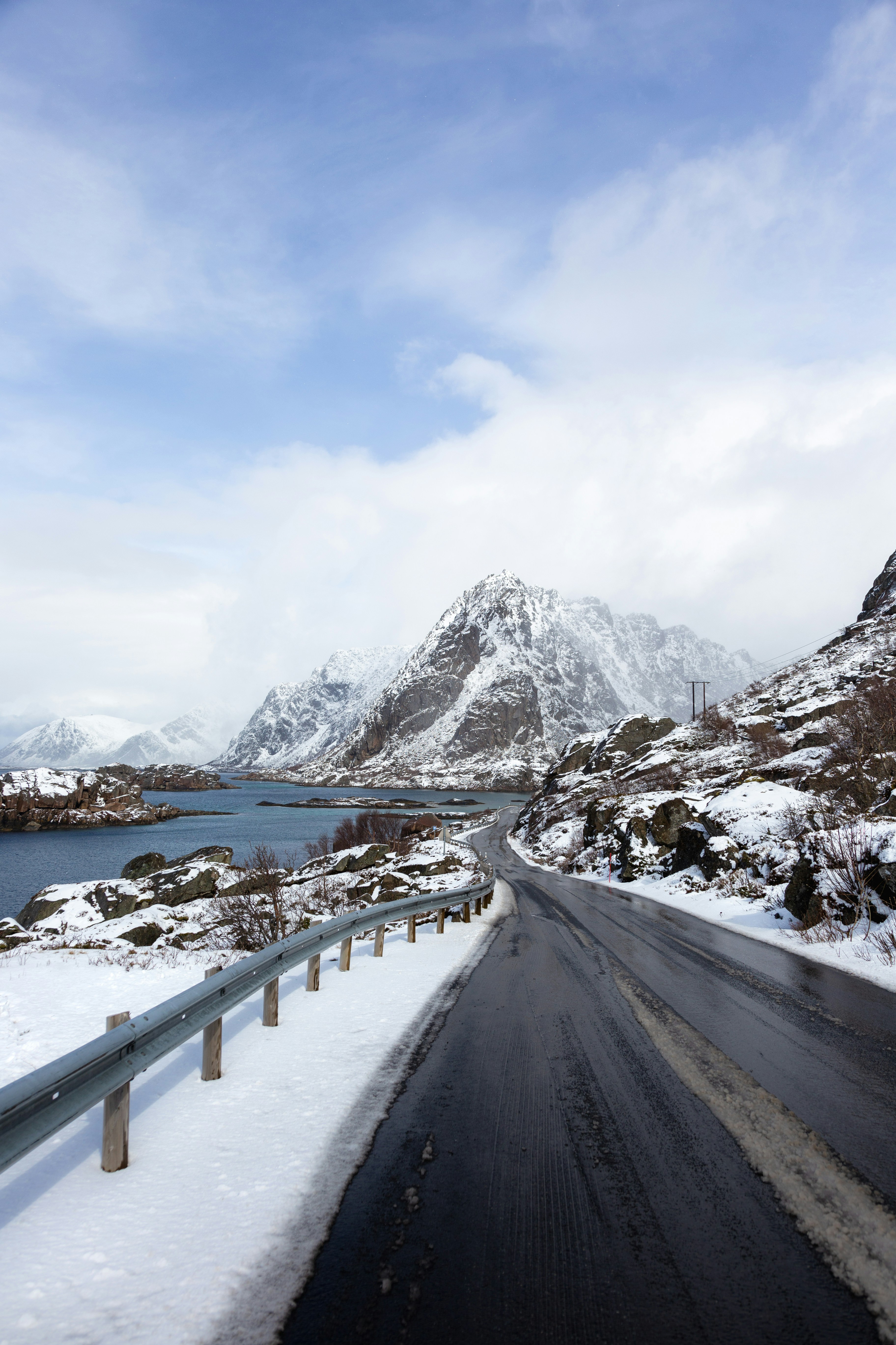 A road with snow on the side and mountains in the background photo ...