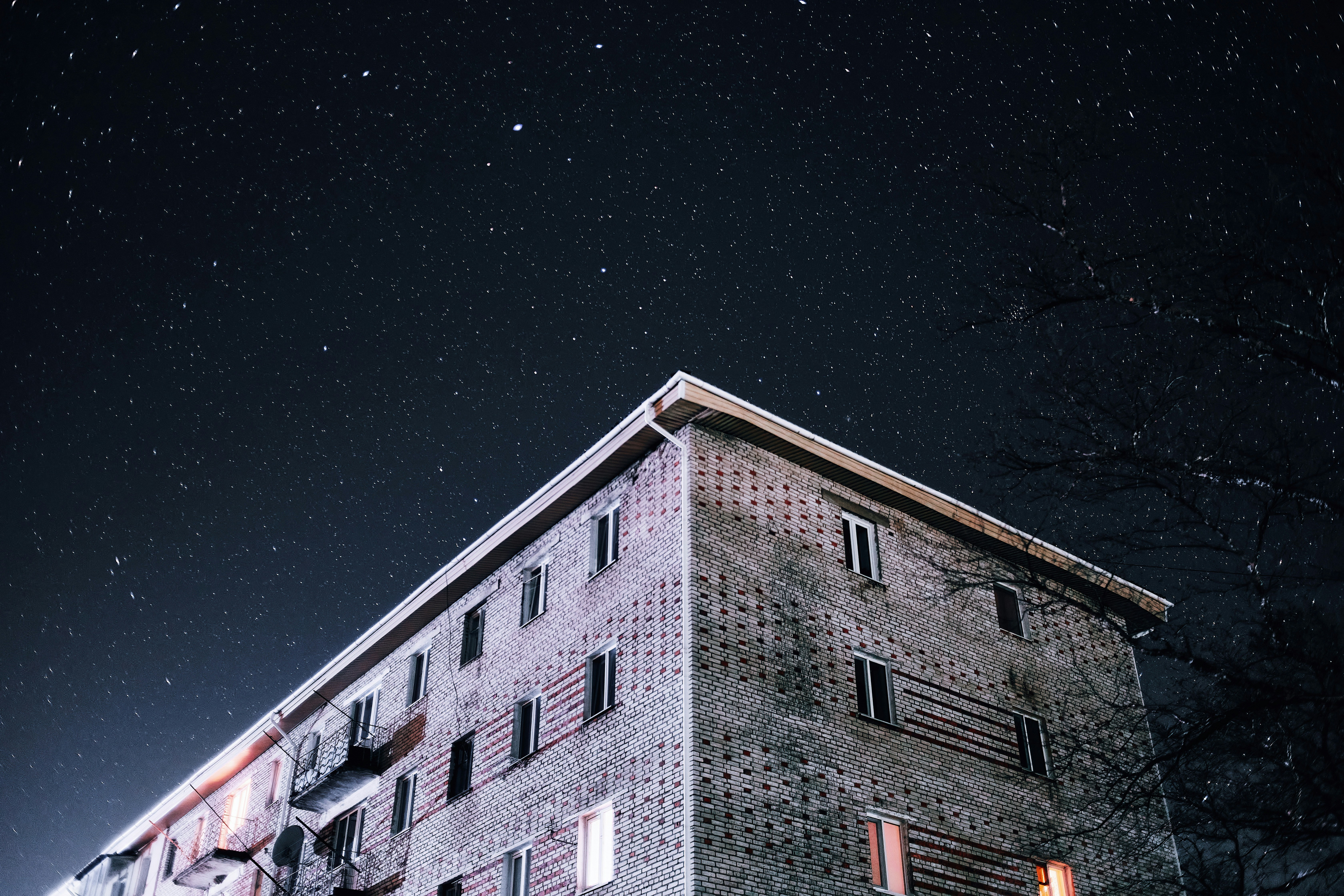 Old apartment building under a star-filled night sky.