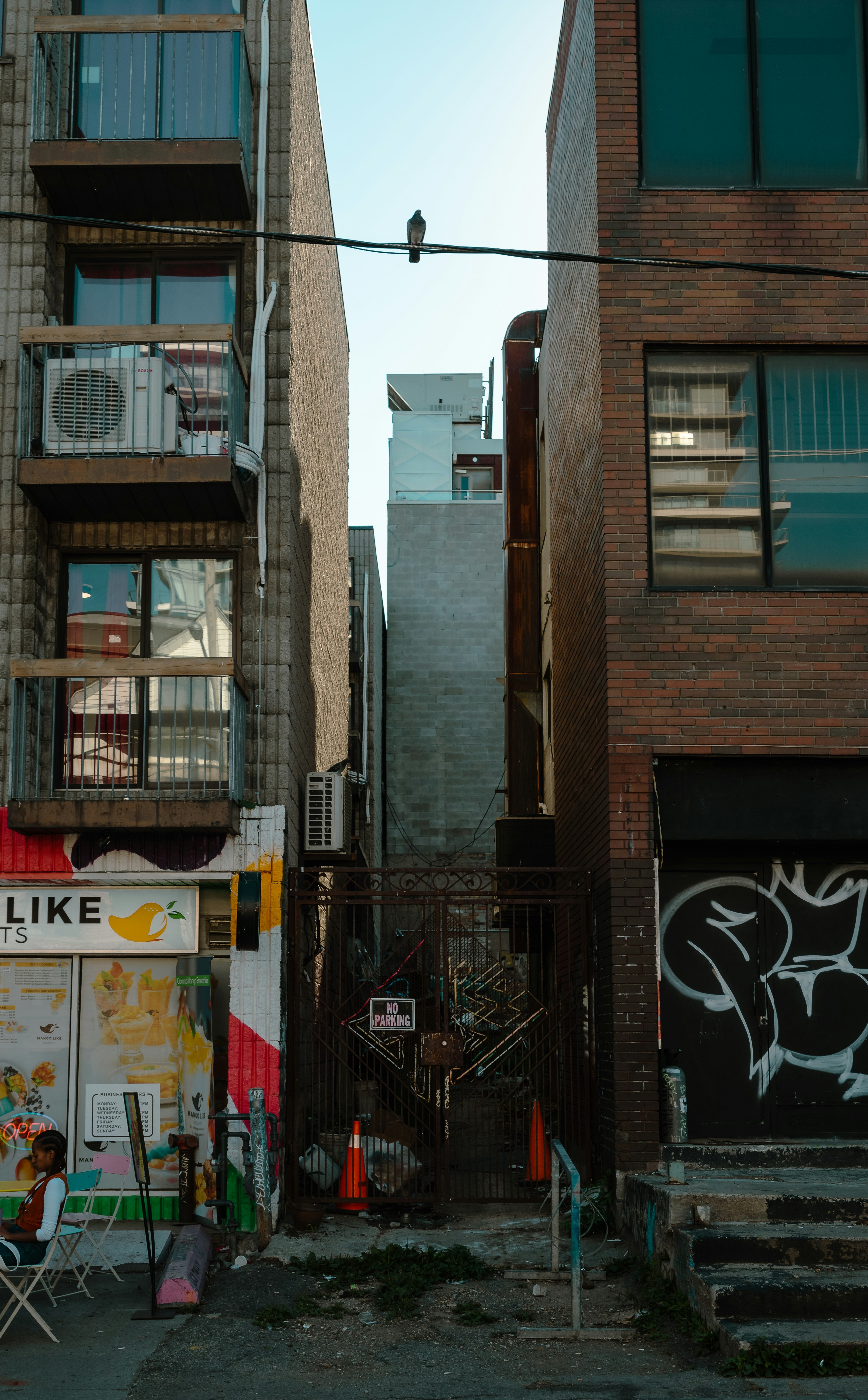 A person sitting on a chair outside a building photo – Free Toronto ...