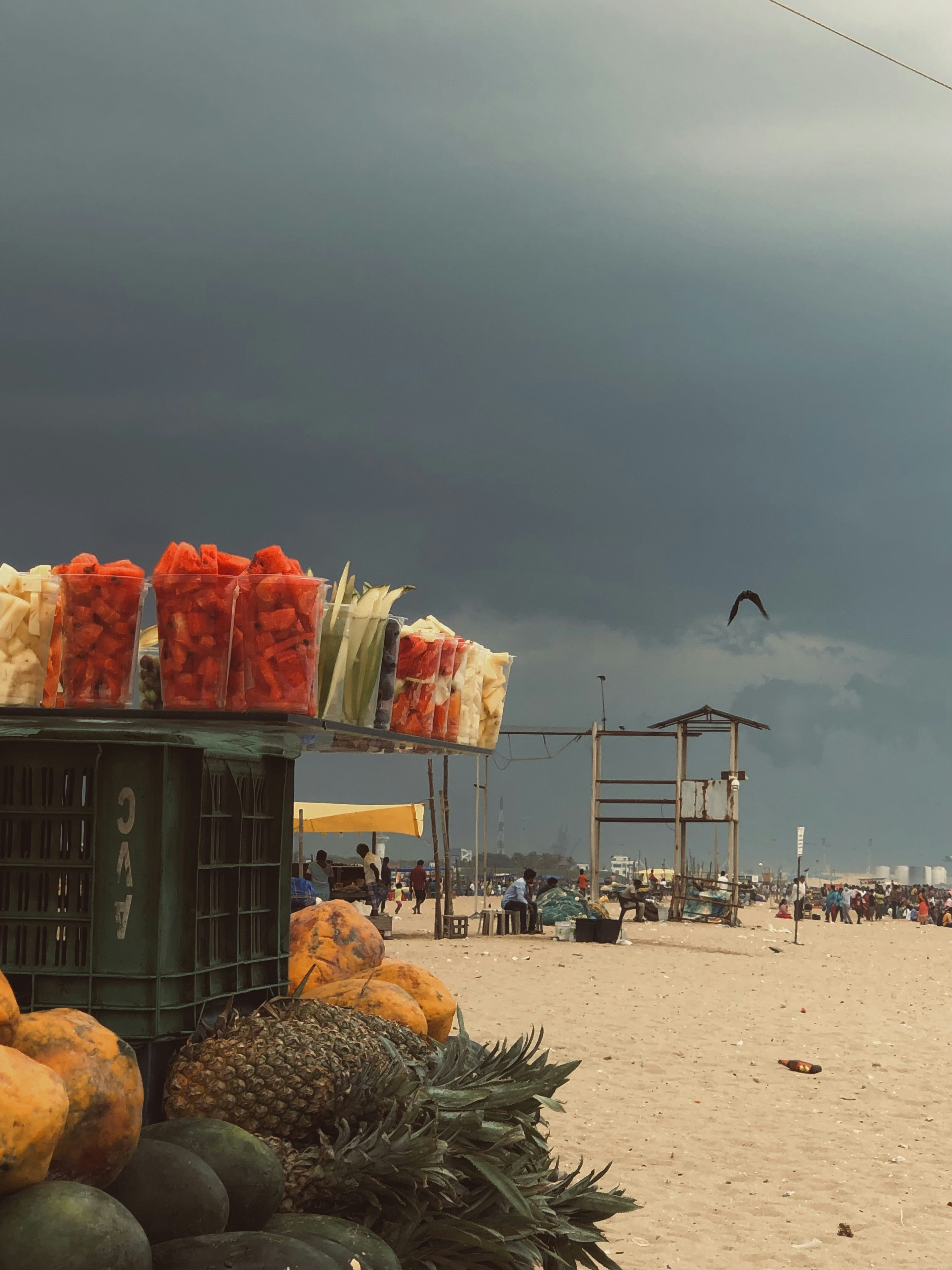 Storm-Tinged Beach Fruit Stand Beside a Distant Lifeguard Tower