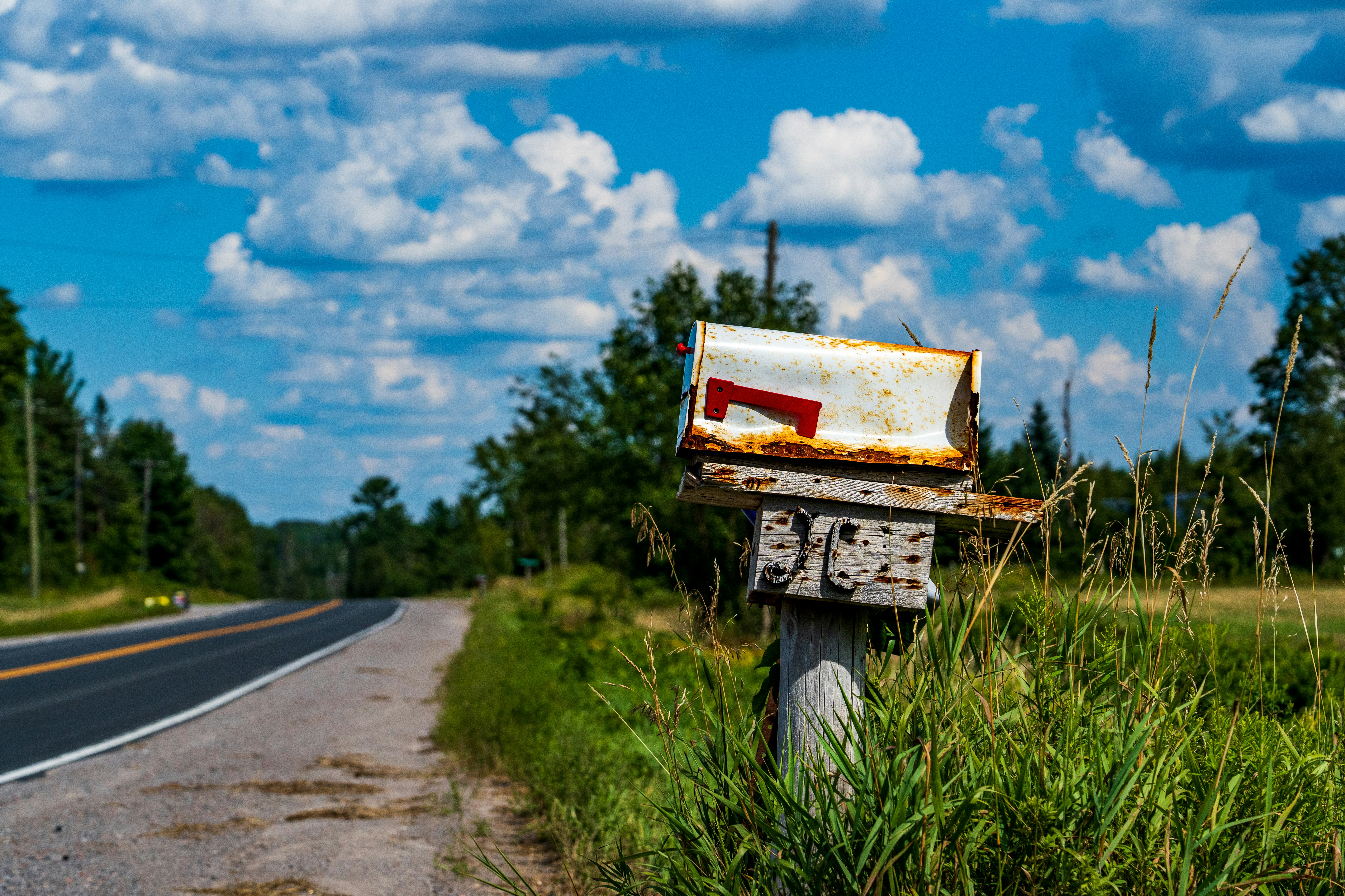 rusty mailbox on an empty country road