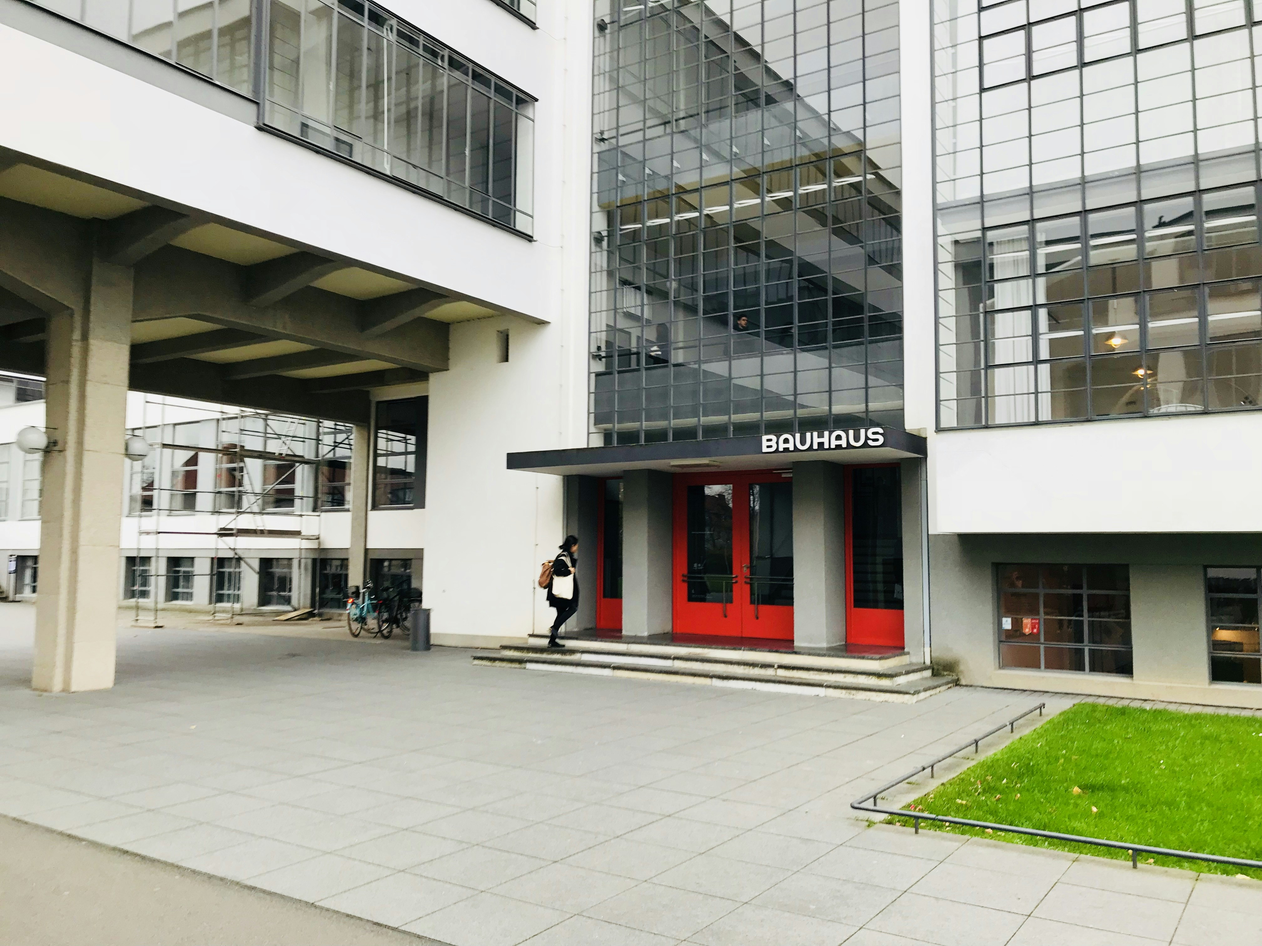 Entrance to the Bauhaus building with red doors framed by geometric architecture.