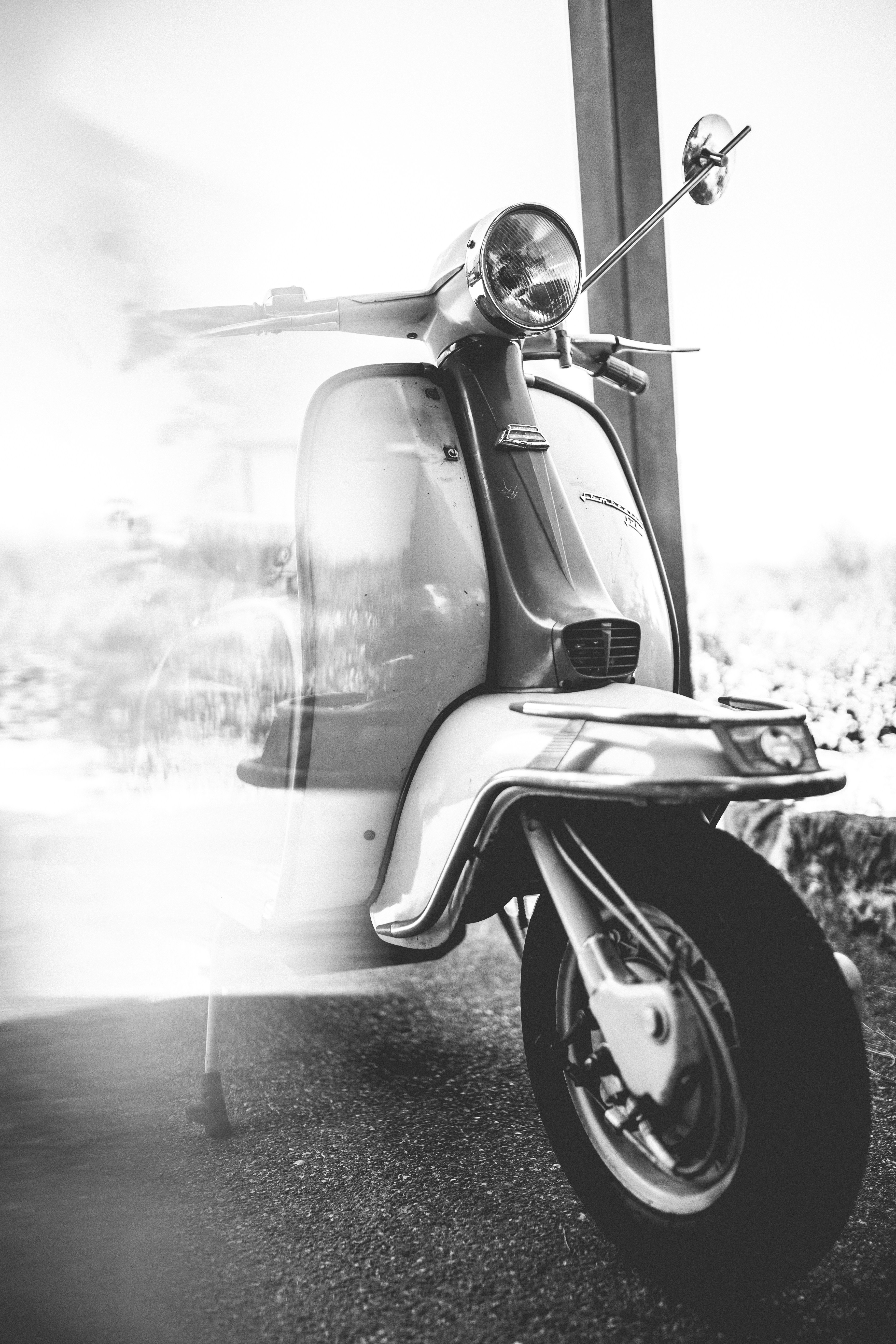 a black and white photo of a scooter parked on a road