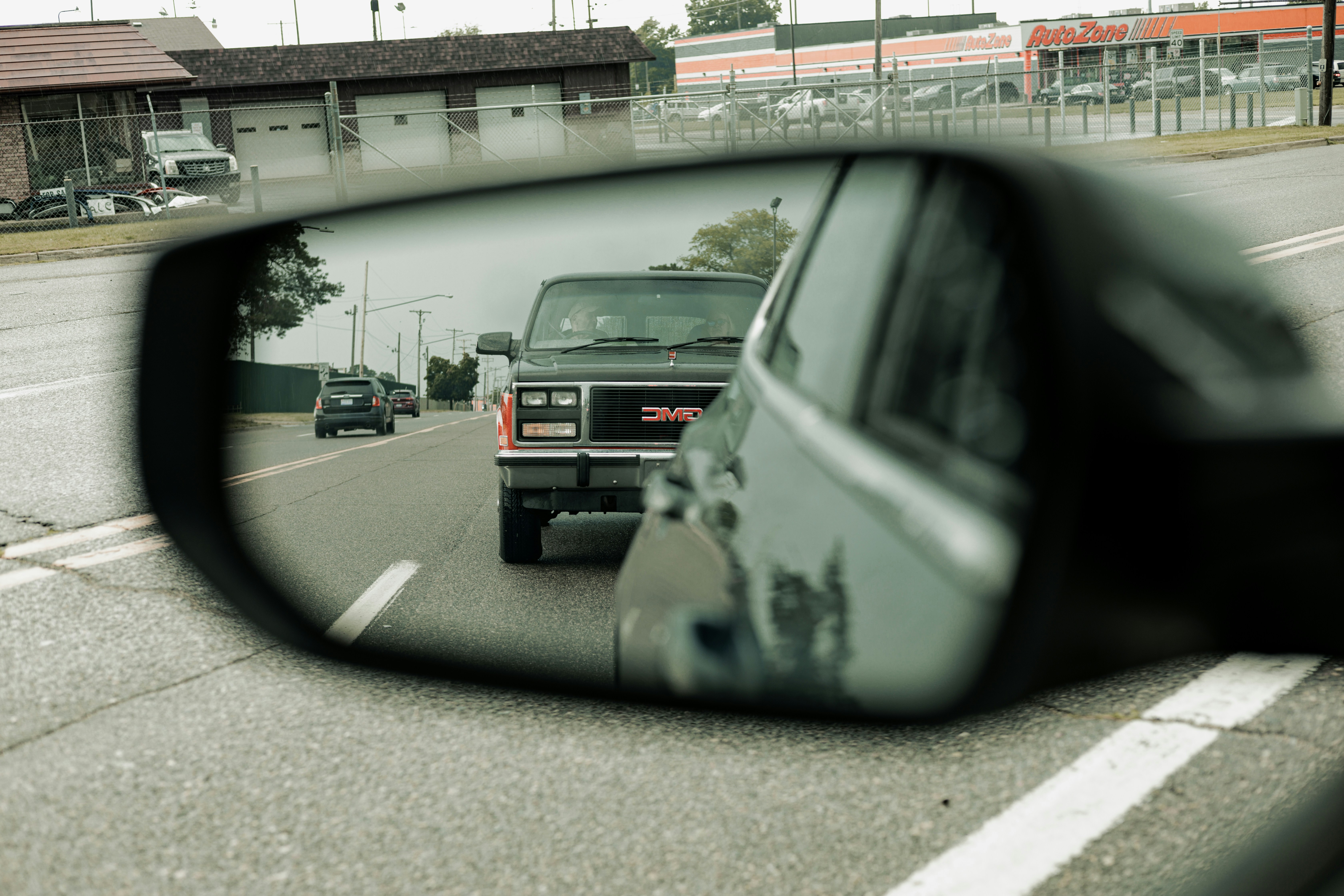 Mirror Lane: A GMC Truck Emerging in the Side View Reflection