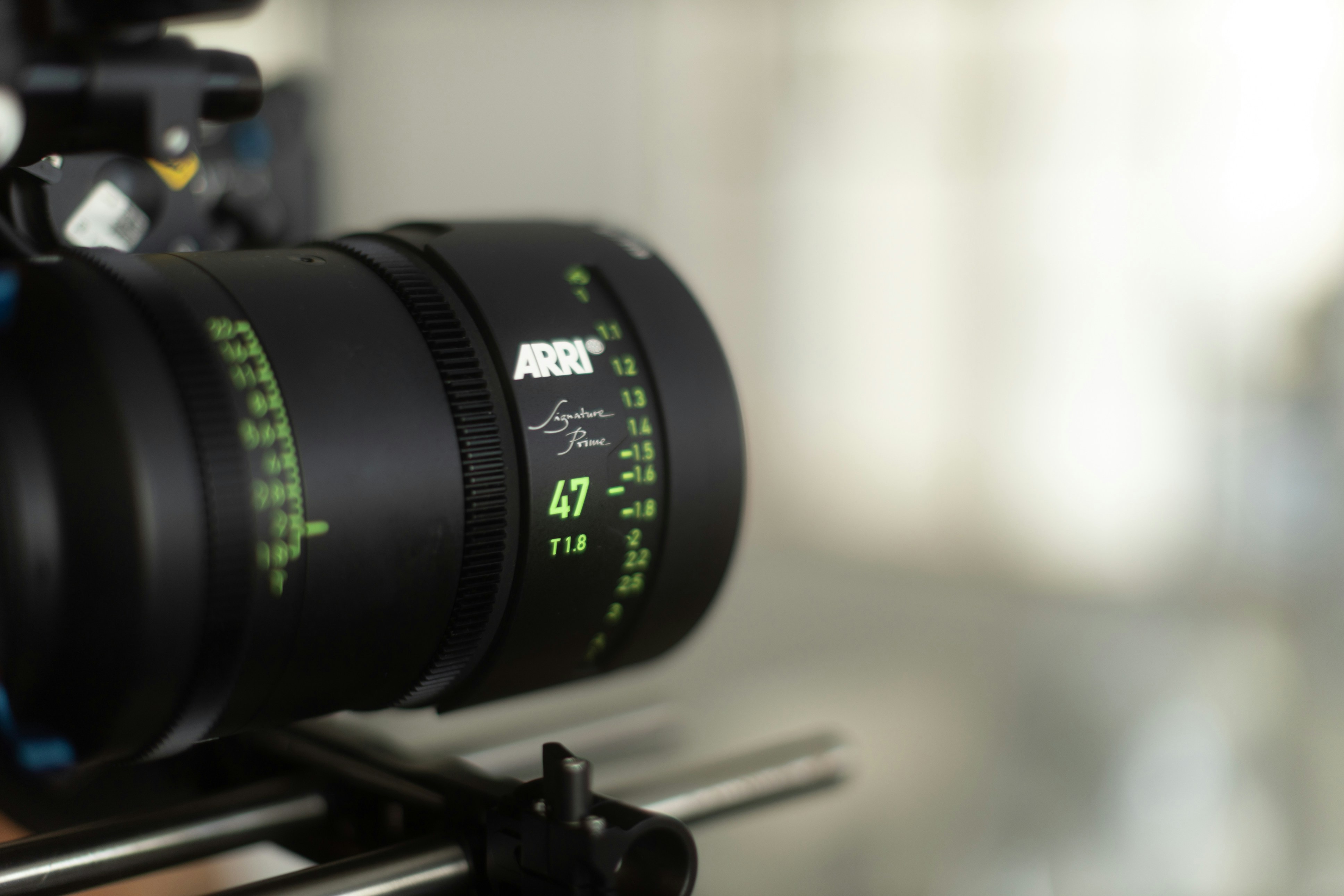 Green-illuminated precision: close-up of an ARRI cine lens on a rail